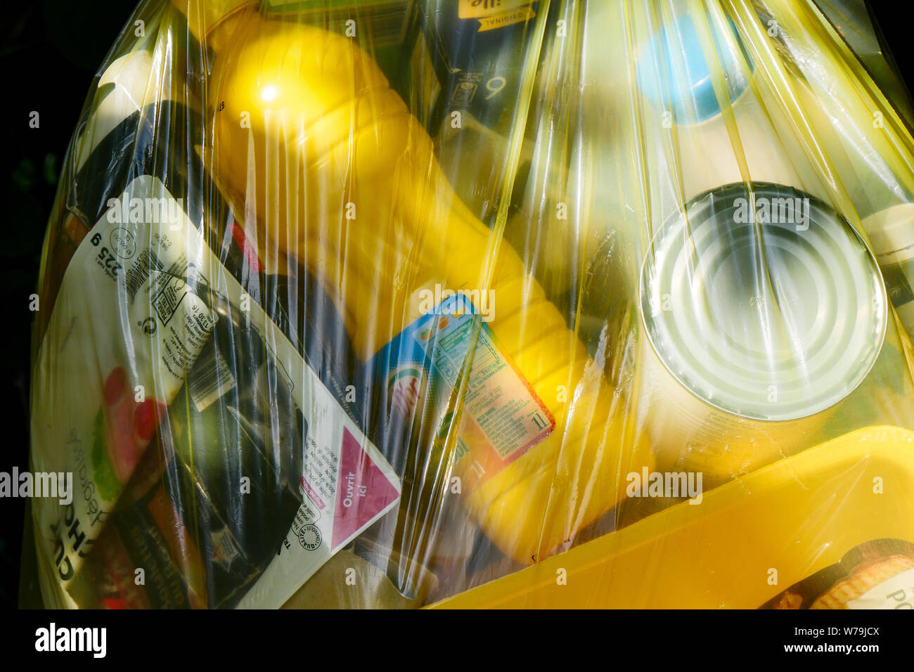 A yellow plastic bag filled with recyclable items hangs at a "Sorting ...