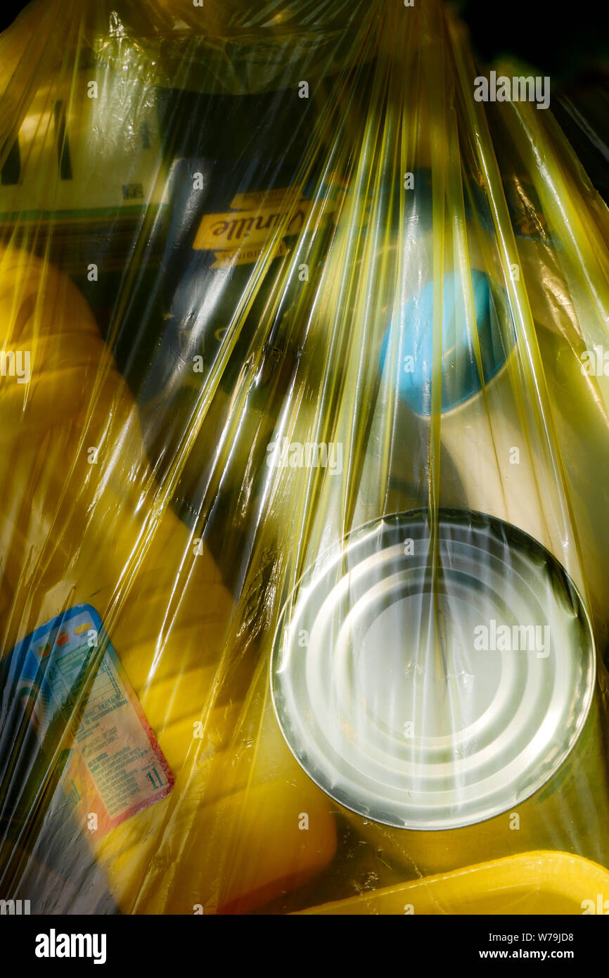 A yellow plastic bag filled with recyclable items hangs at a "Sorting ...