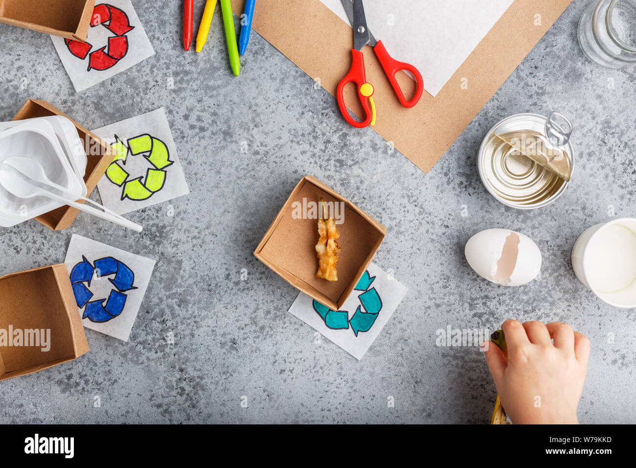 Girl hands are making recycling game in paper on grey background ...