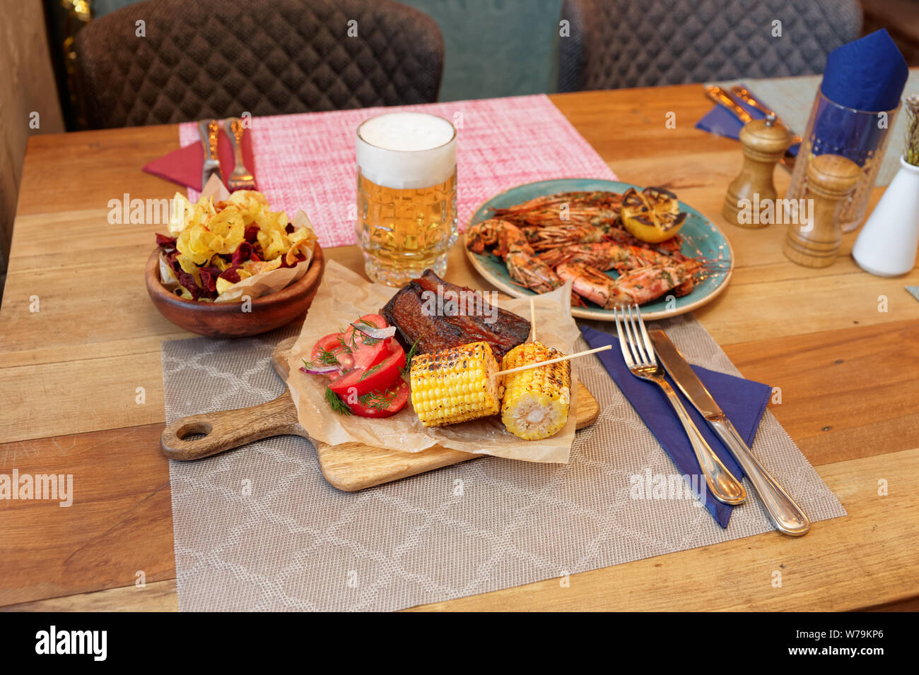Unhealthy pub food - grilled meat, corn, potato chips and beer on ...