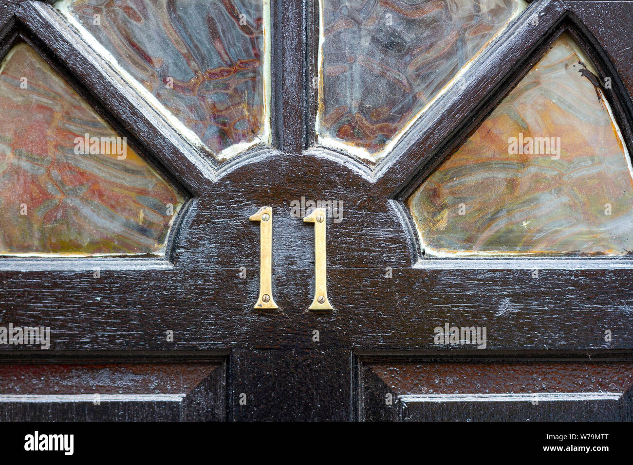 House number 11 on a brown front door with glass inserts and diagonal ...