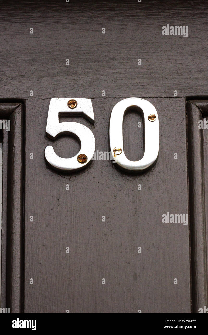 House number 50 in silver metal digits on a black wooden front door ...