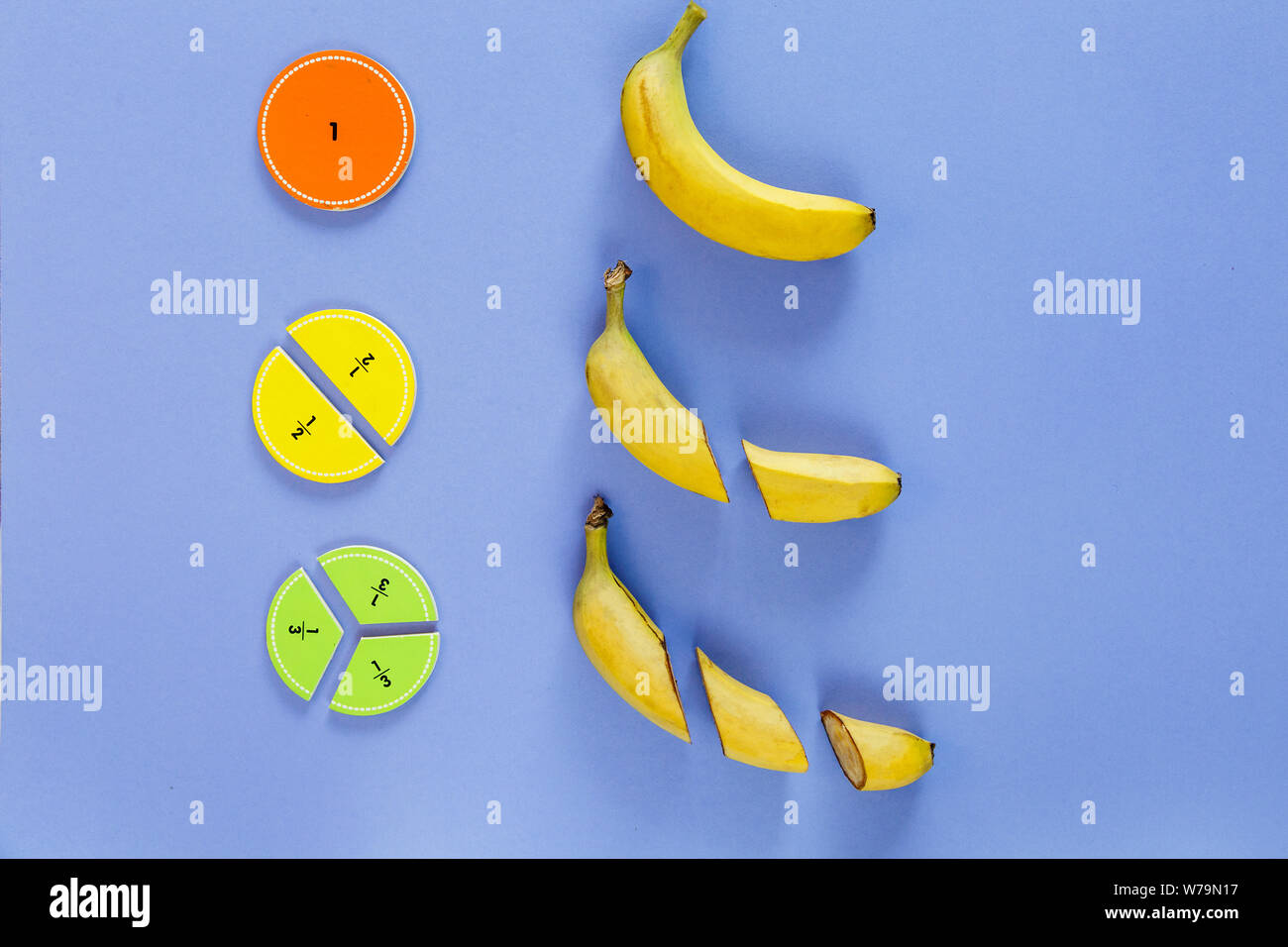 Сolorful math fractions and bananas as a sample on violet wooden ...