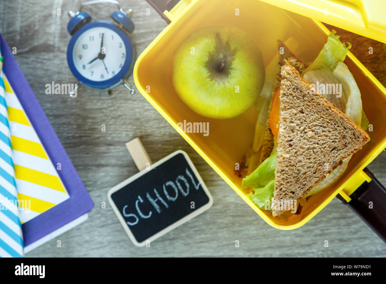 School yellow lunch box with sandwich, green apple, clock on chalkboard ...
