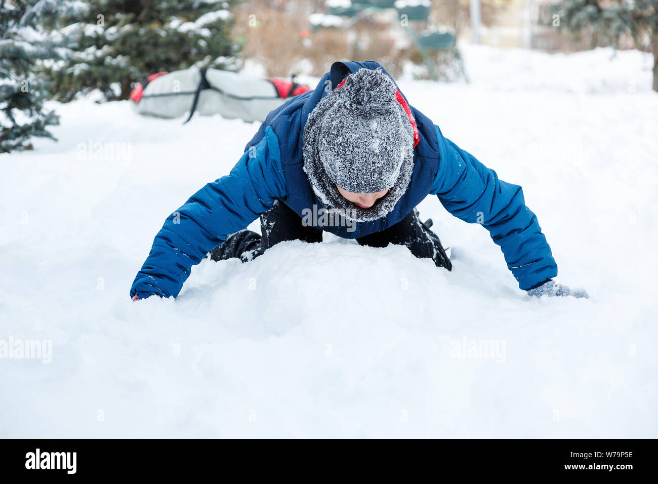 Happy cute excited boy teenager plays with snow, makes snowballs ...