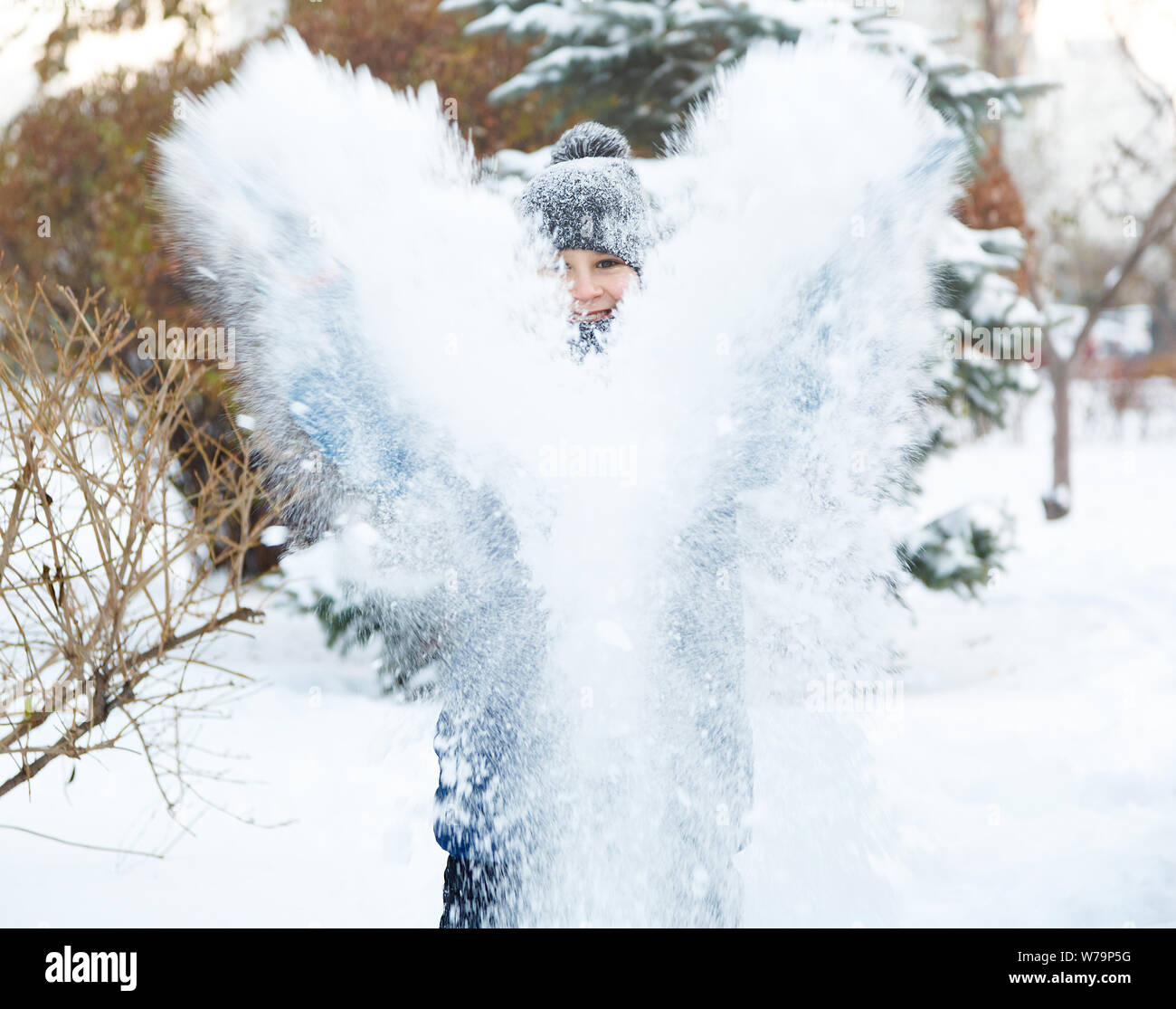 Happy cute excited boy teenager plays with snow, makes snowballs ...
