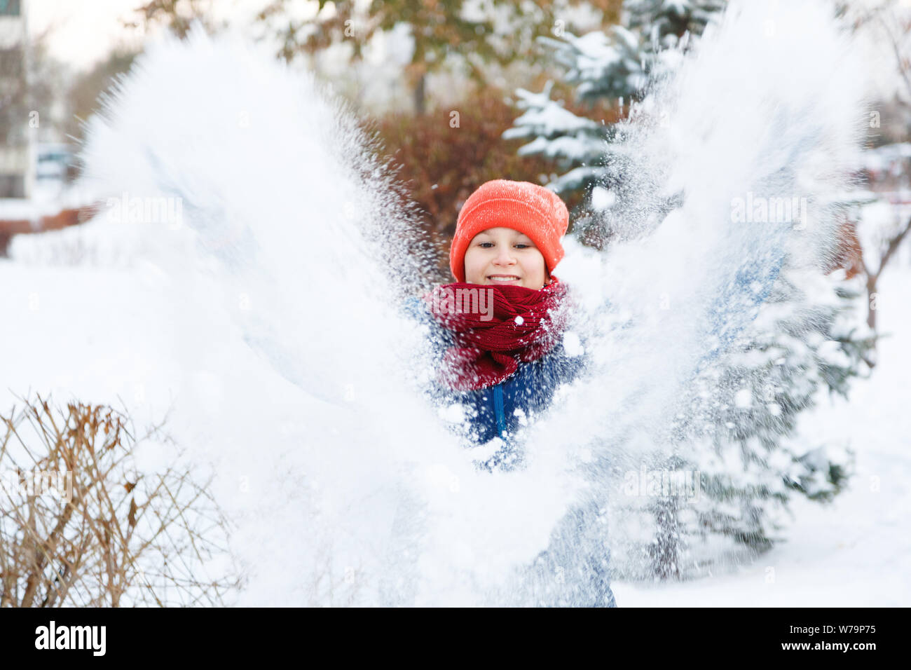 Happy cute excited boy teenager plays with snow, makes snowballs ...