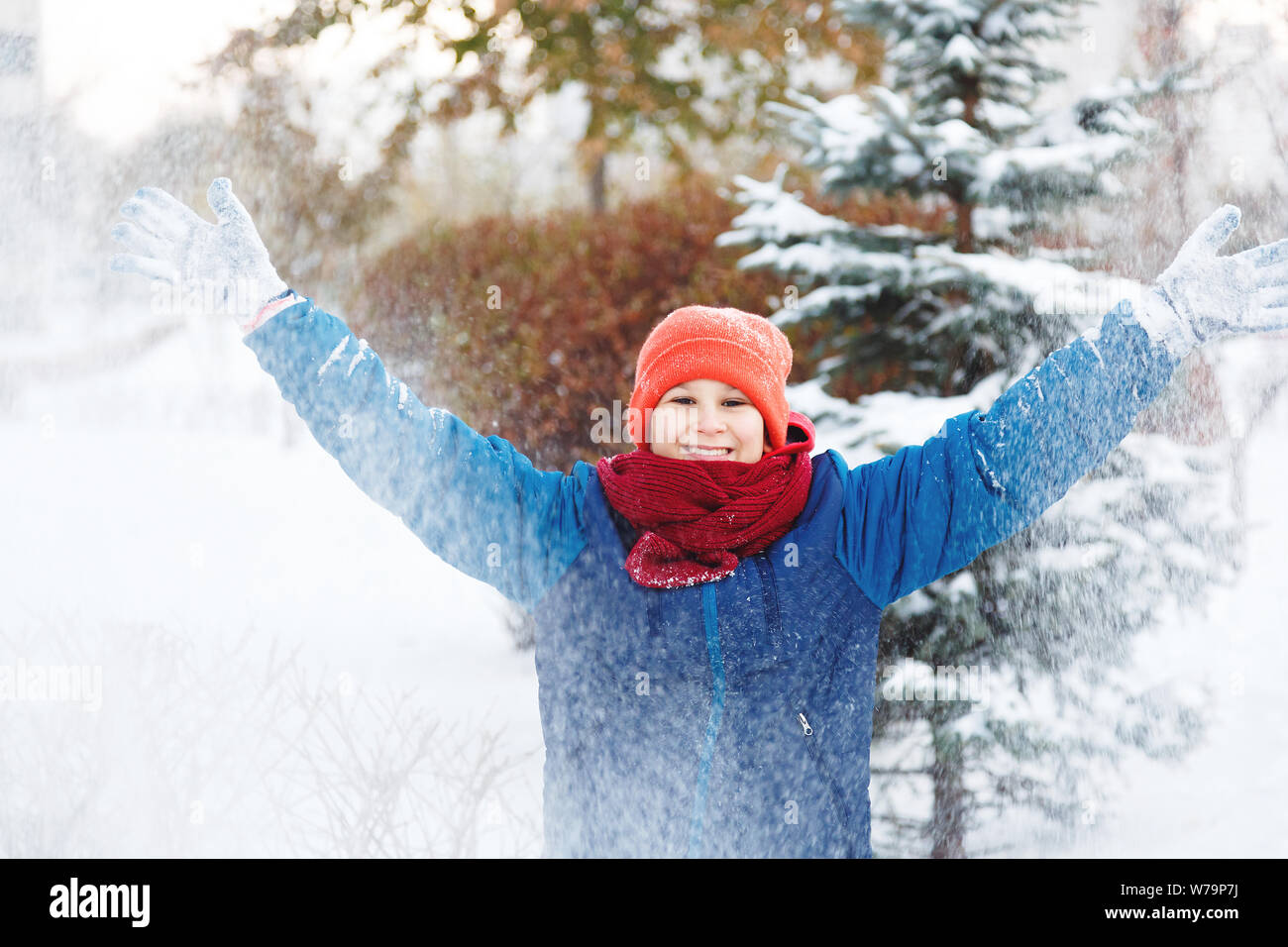 Happy cute excited boy teenager plays with snow, makes snowballs ...