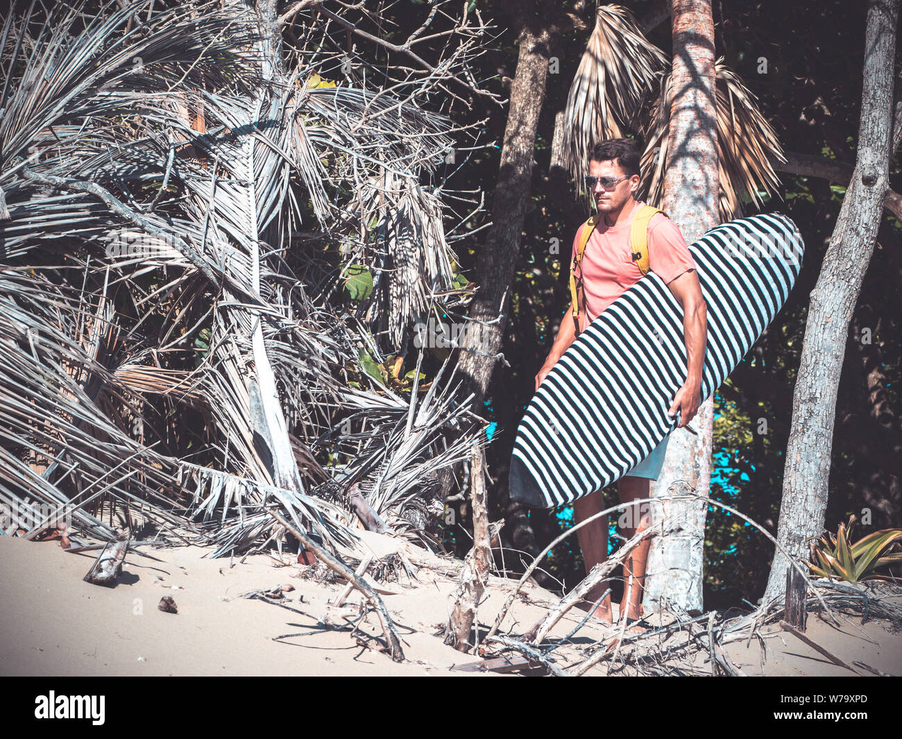 Male surfer checks the waves on the beach Stock Photo - Alamy