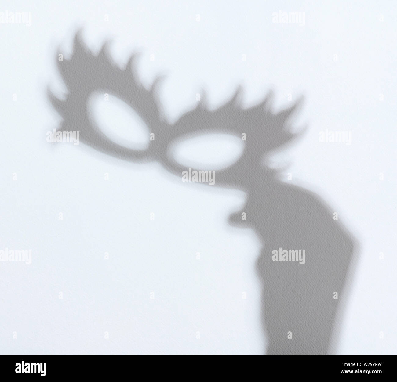 Shadow of face mask in hand on white wall background Stock Photo - Alamy