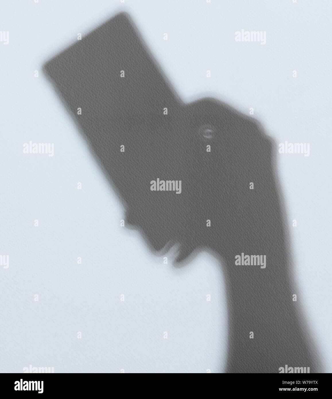Shadow of smatphone in hand taking selfie on white wall background ...