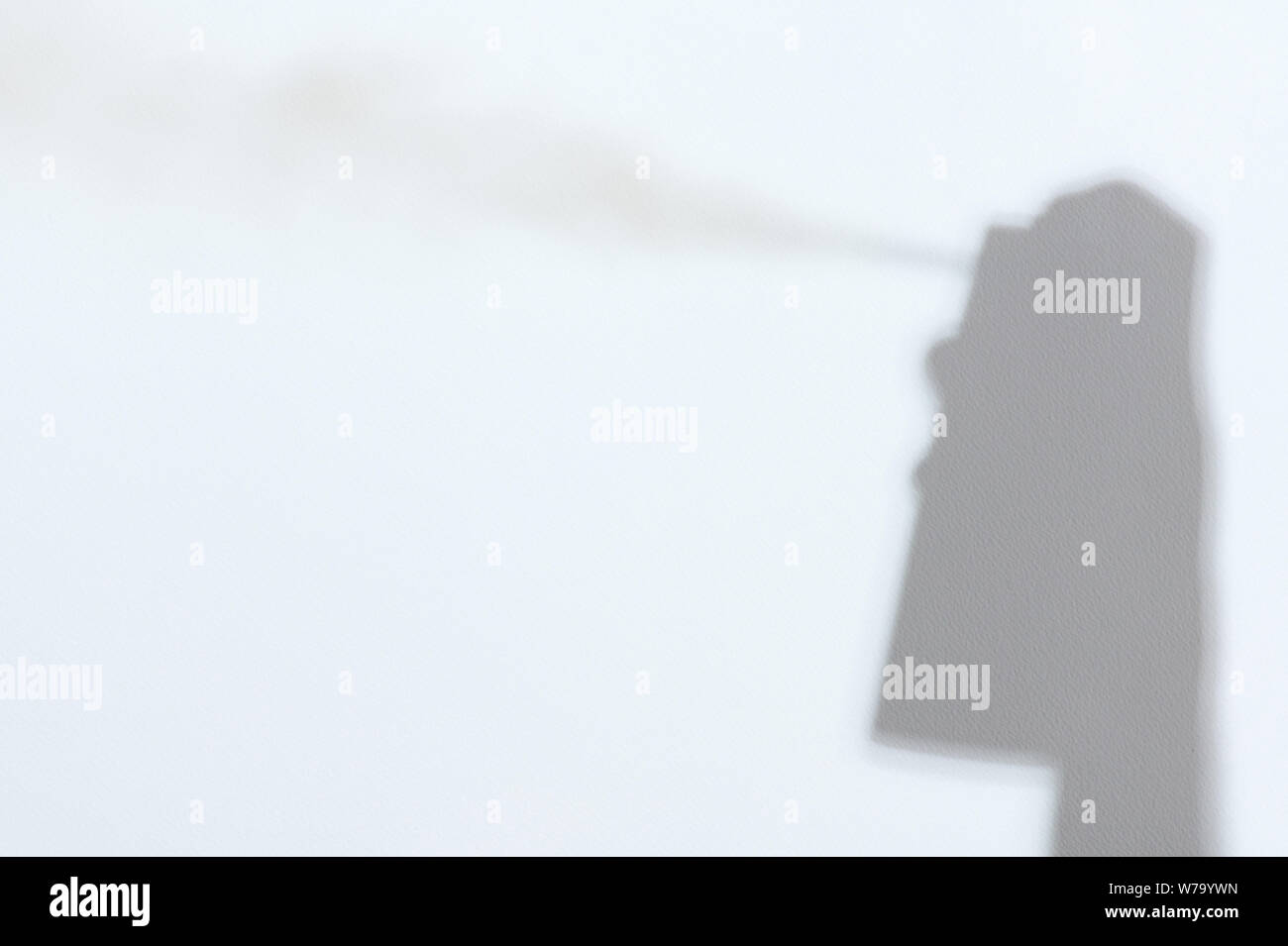 Shadow of spraying bottle on white wall background Stock Photo - Alamy