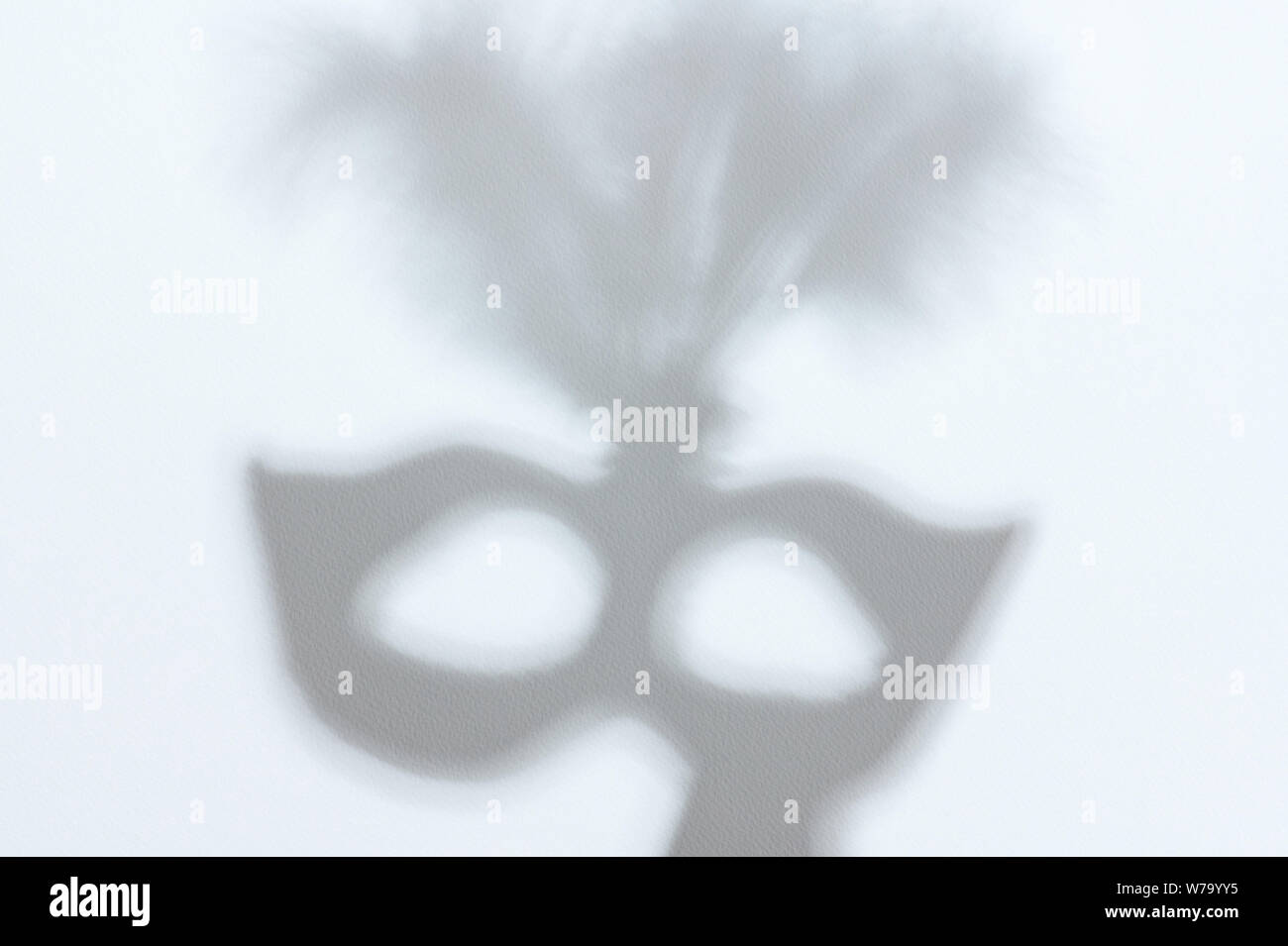 Shadow of face mask on white wall background Stock Photo - Alamy