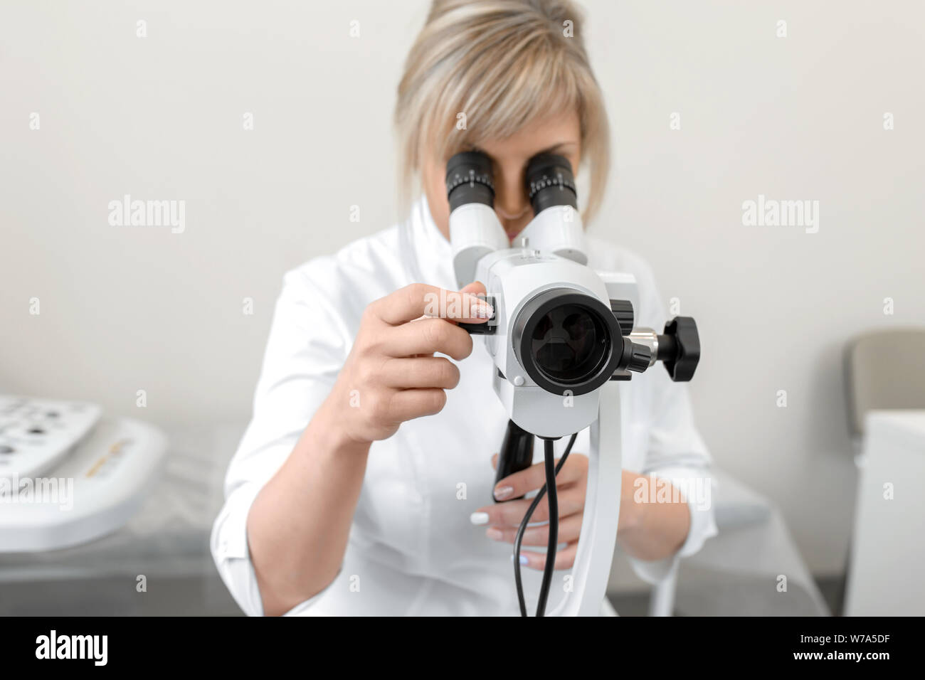 Young female professional gynecologist in the working process, looks ...