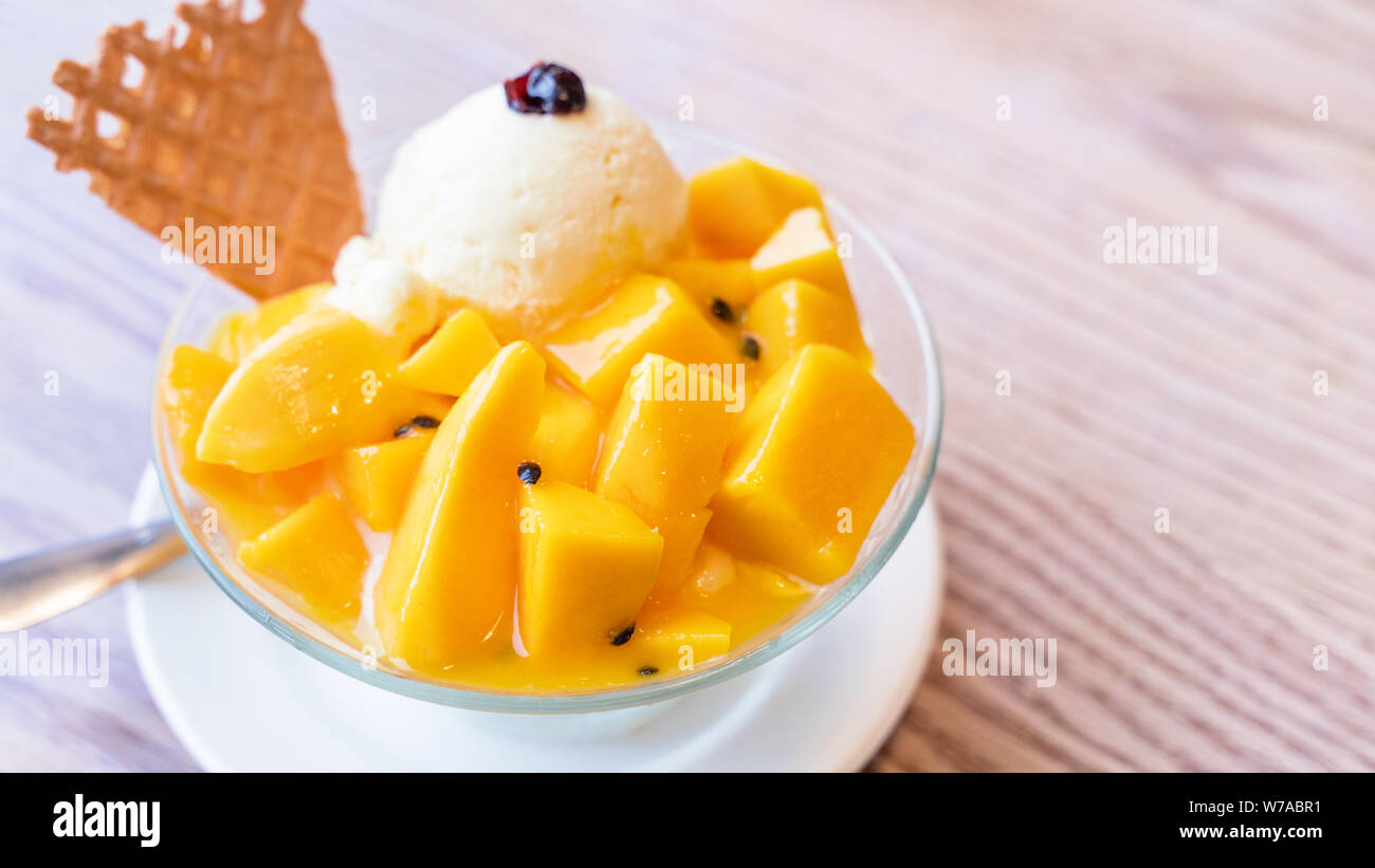 Fresh mango shaved ice with a scoop of ice cream and juice sauce in ...