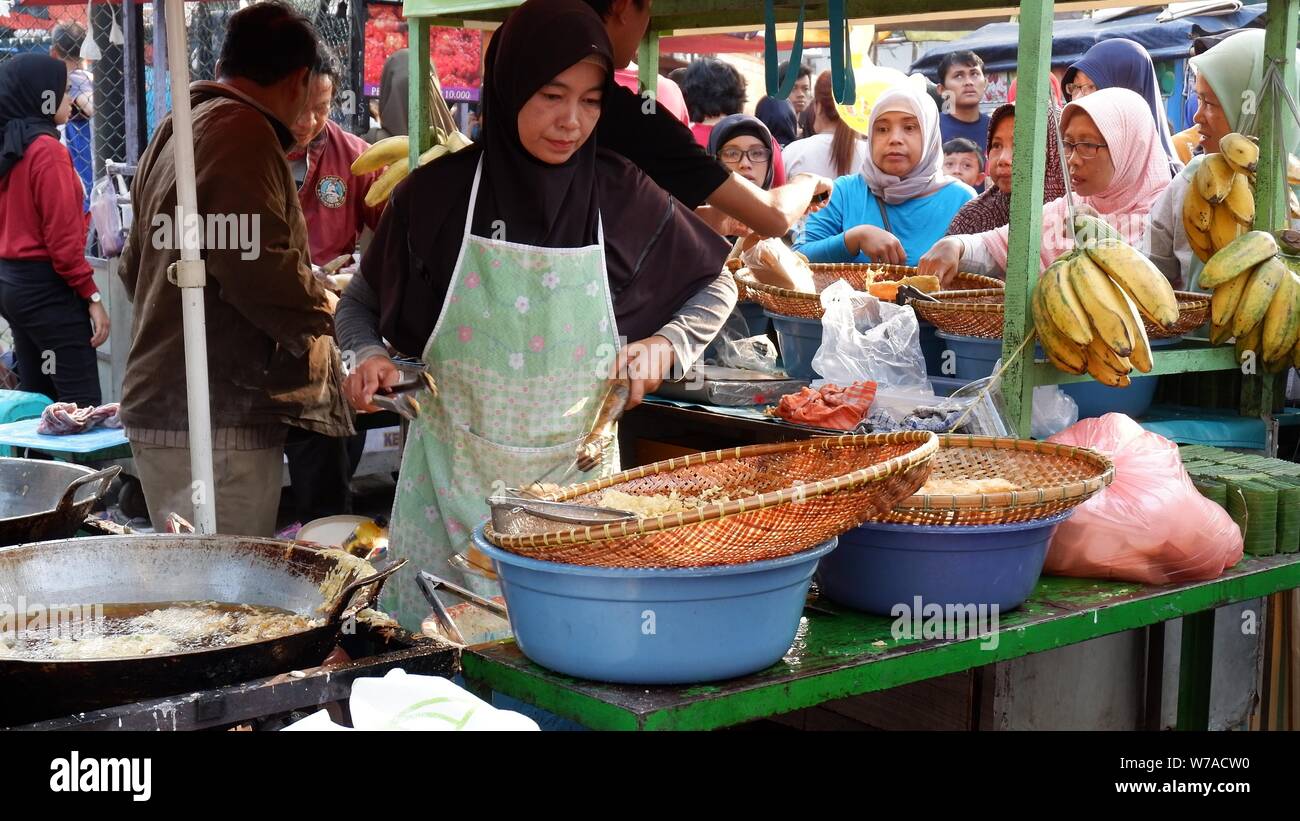Jakarta, Indonesia - August 2019 : A muslim woman are frying bananas ...