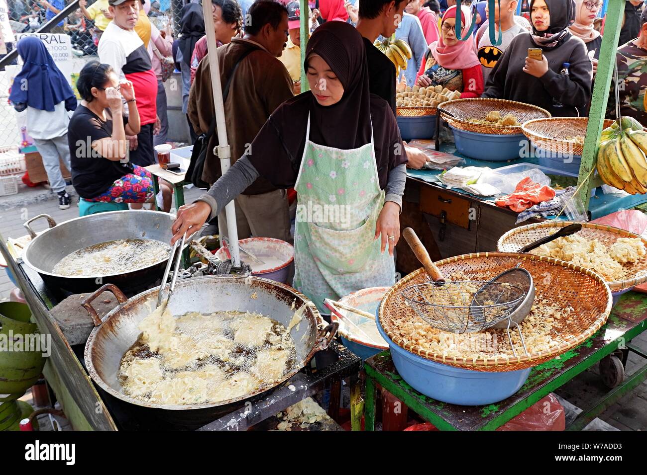 Jakarta, Indonesia - August 2019 : A muslim woman are frying bananas ...