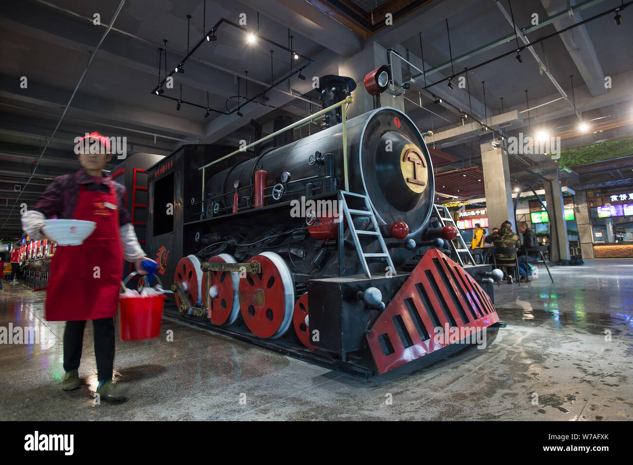 A worker walks past a model "steam train" in the canteen of Wuhan ...