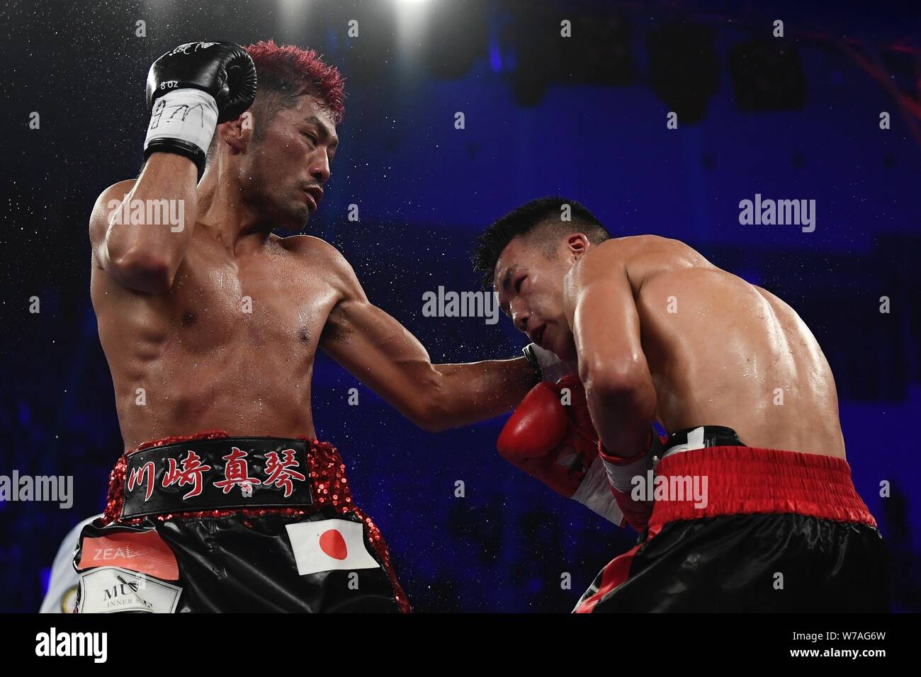 Japanese boxer Makoto Kawasaki, left, hits Chinese boxer Yang Xingxin ...