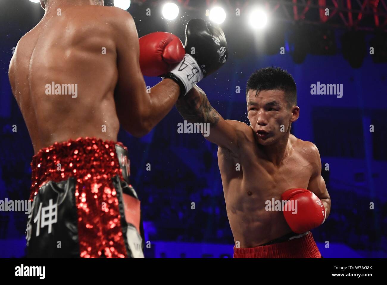 Chinese boxer Yang Xingxin, right, hits Japanese boxer Makoto Kawasaki ...