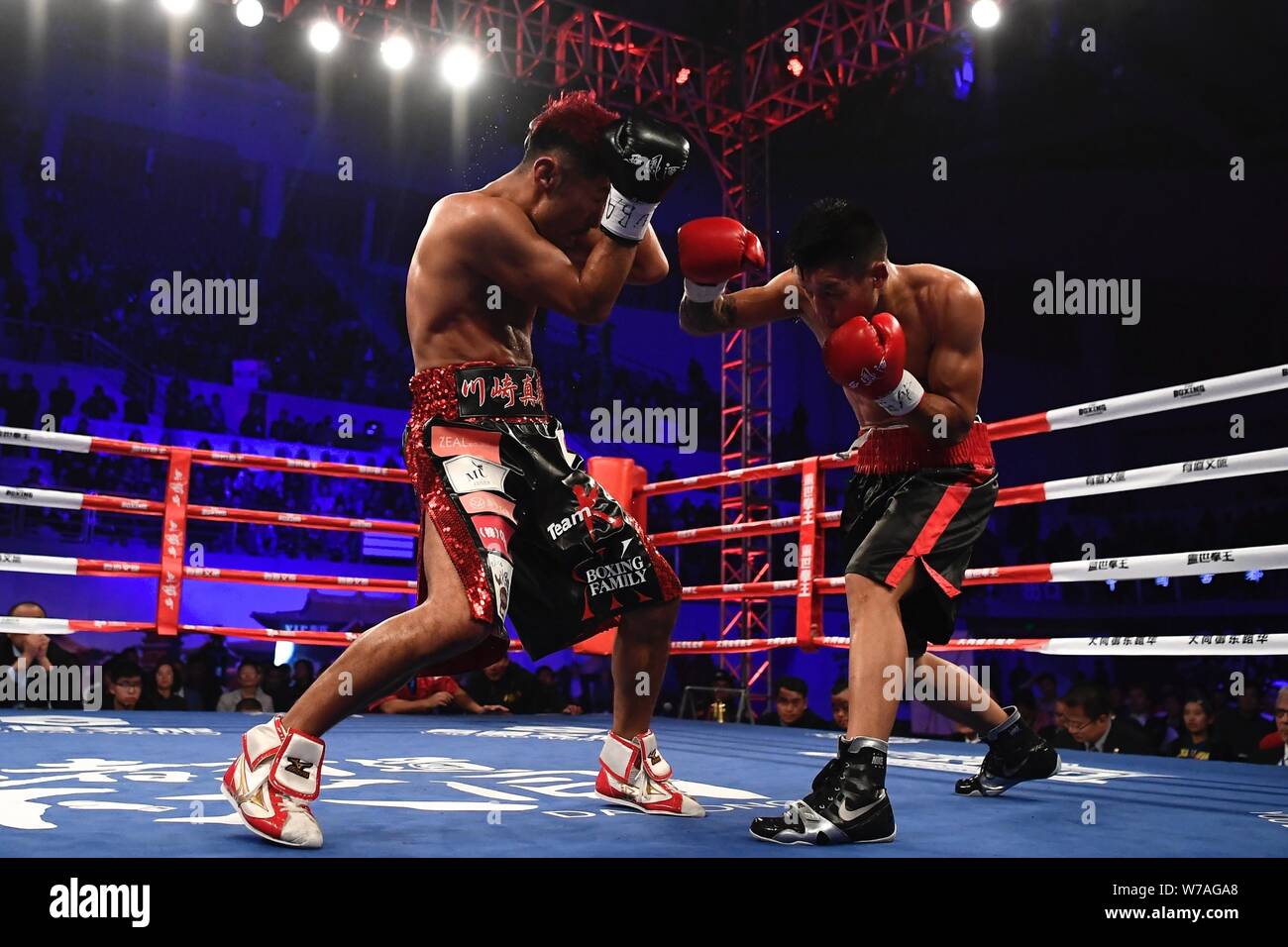 Japanese boxer Makoto Kawasaki, left, hits Chinese boxer Yang Xingxin ...