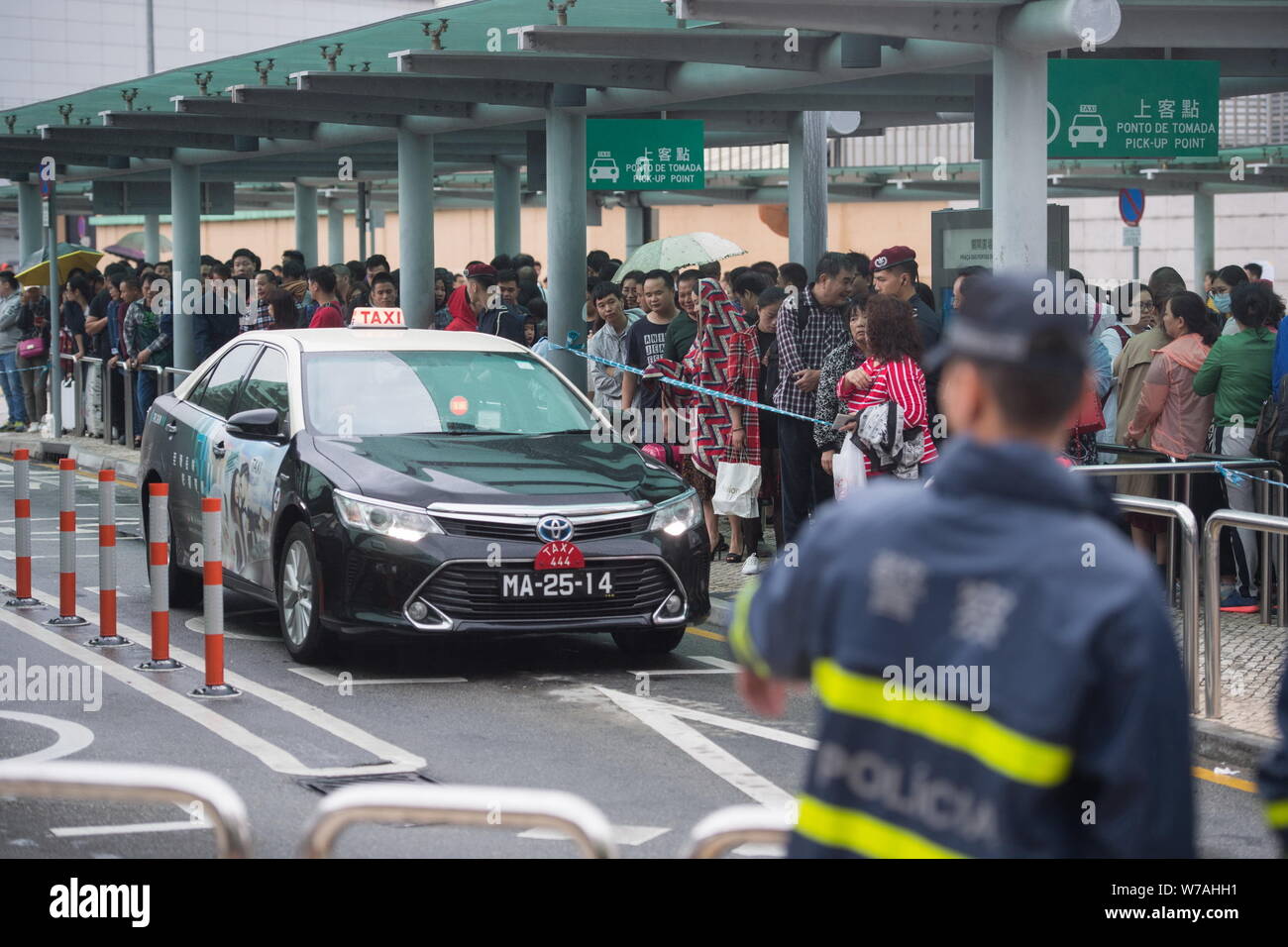 Local residents queue up in a long line to wait for taxis due to the ...