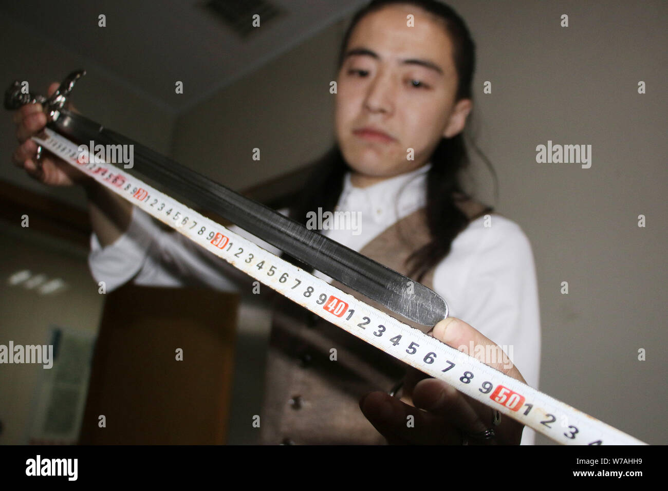 Chinese acrobat Wang Lei measures the length of his sword before his ...
