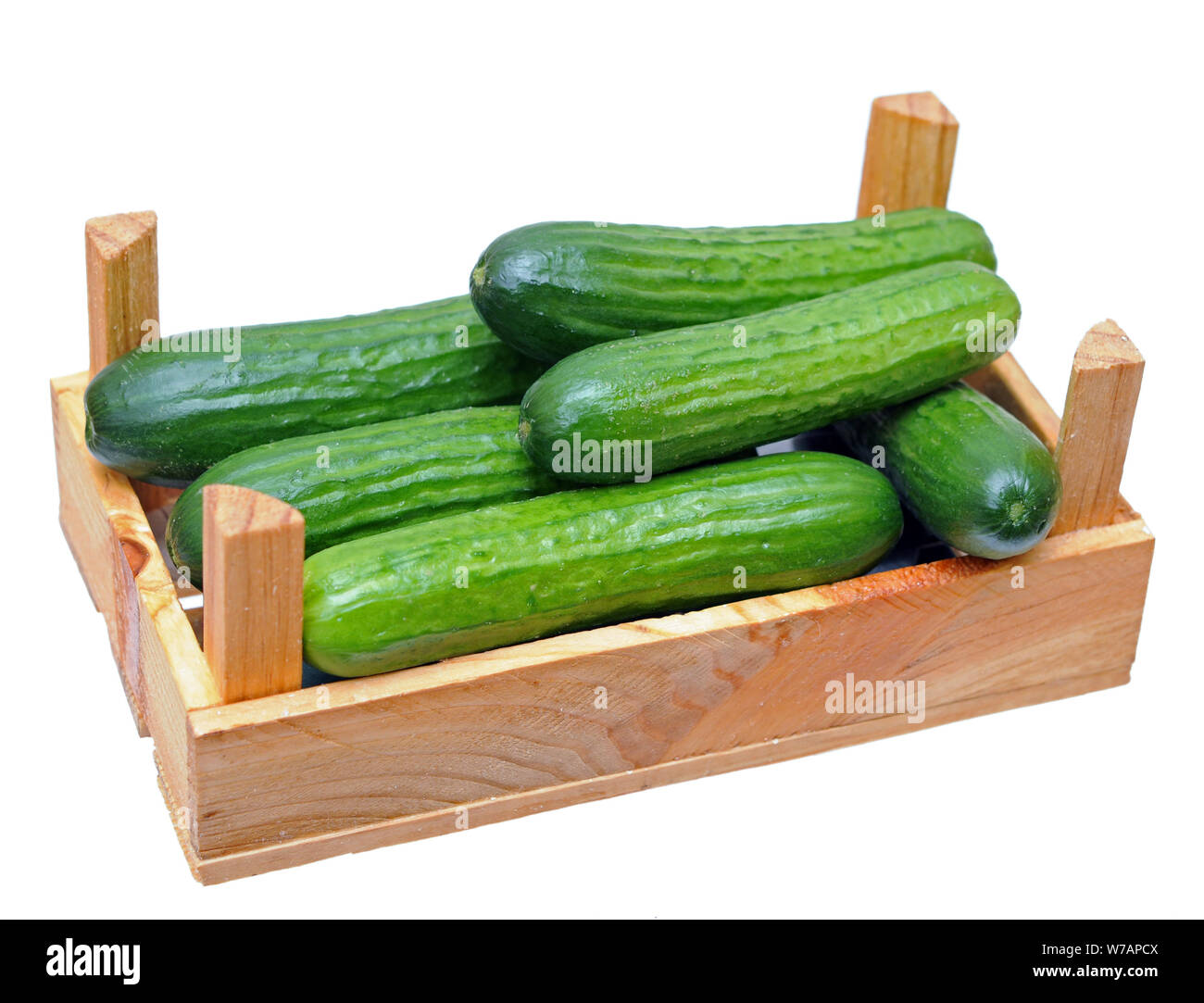 cutting and whole cucumber in wooden crate isolated on white background ...