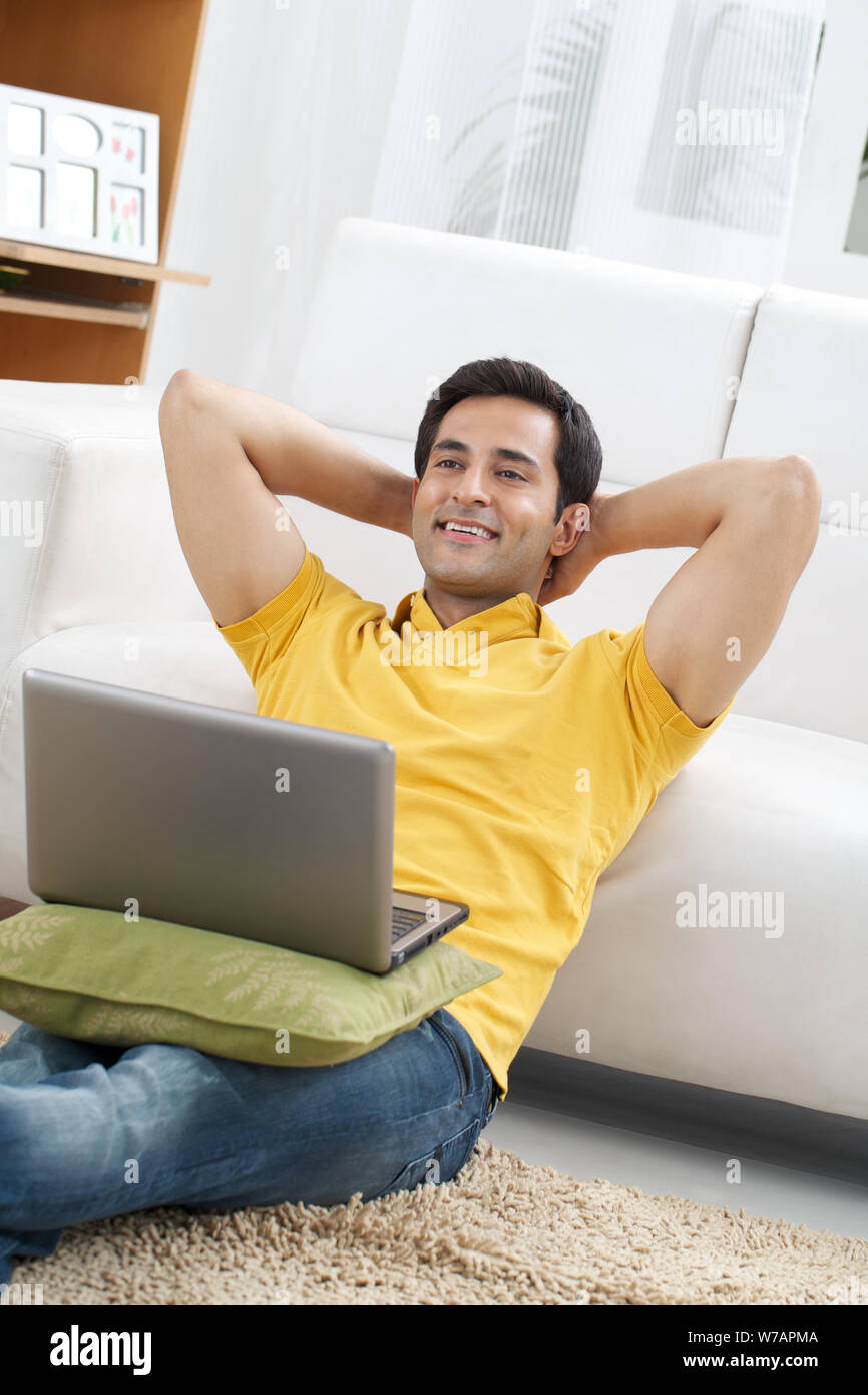 Young man relaxing with laptop Stock Photo - Alamy