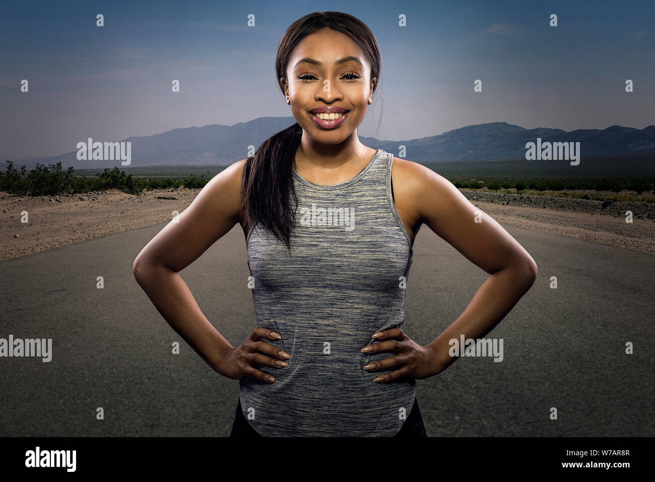 Athletic black African American female runner or jogger resting to pose ...