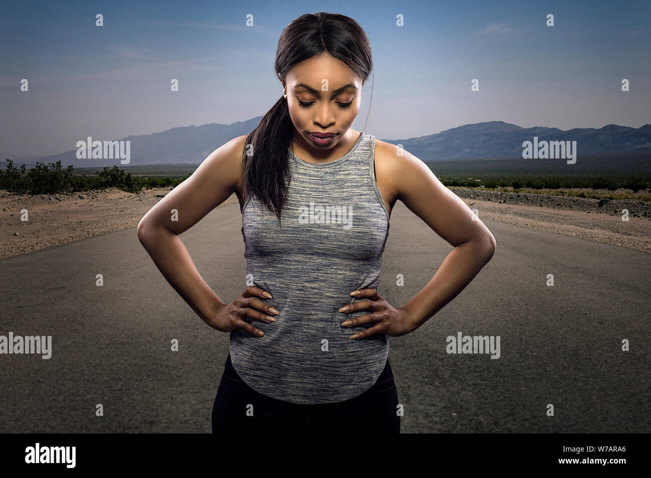 Athletic black African American female runner or jogger resting to pose ...