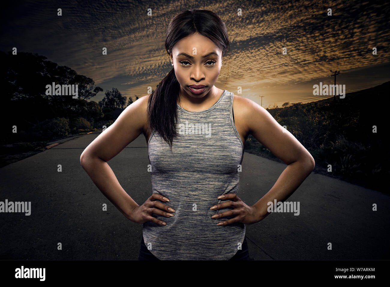 Athletic black African American female runner or jogger resting to pose ...