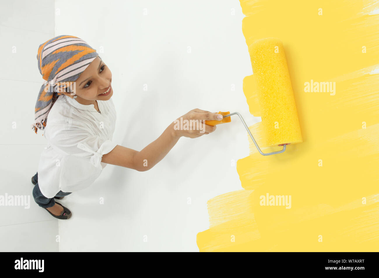 Side view of girl painting wall at home hi-res stock photography and ...