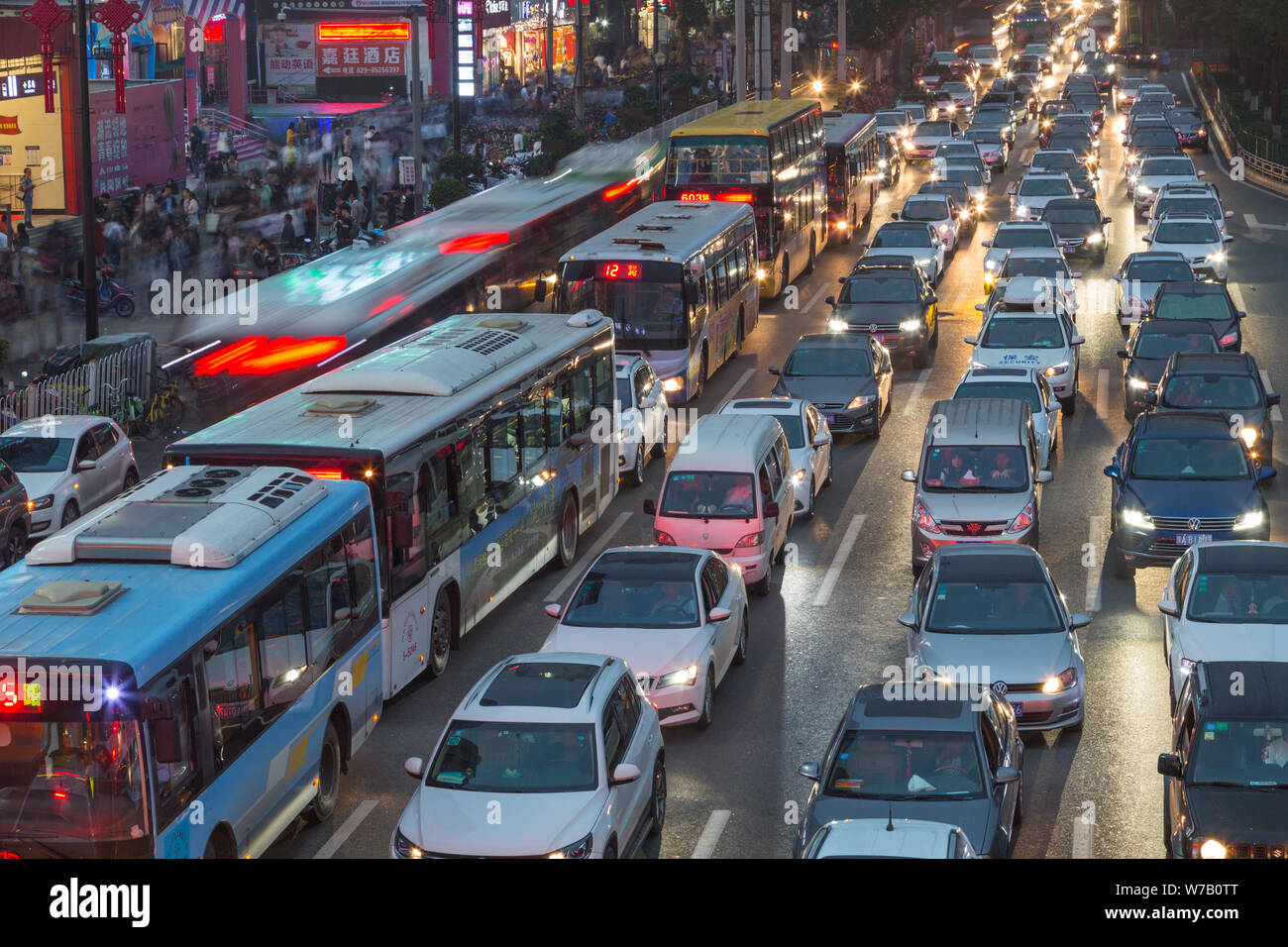 Masses of vehicles move slowly on a road in a traffic jam during rush ...