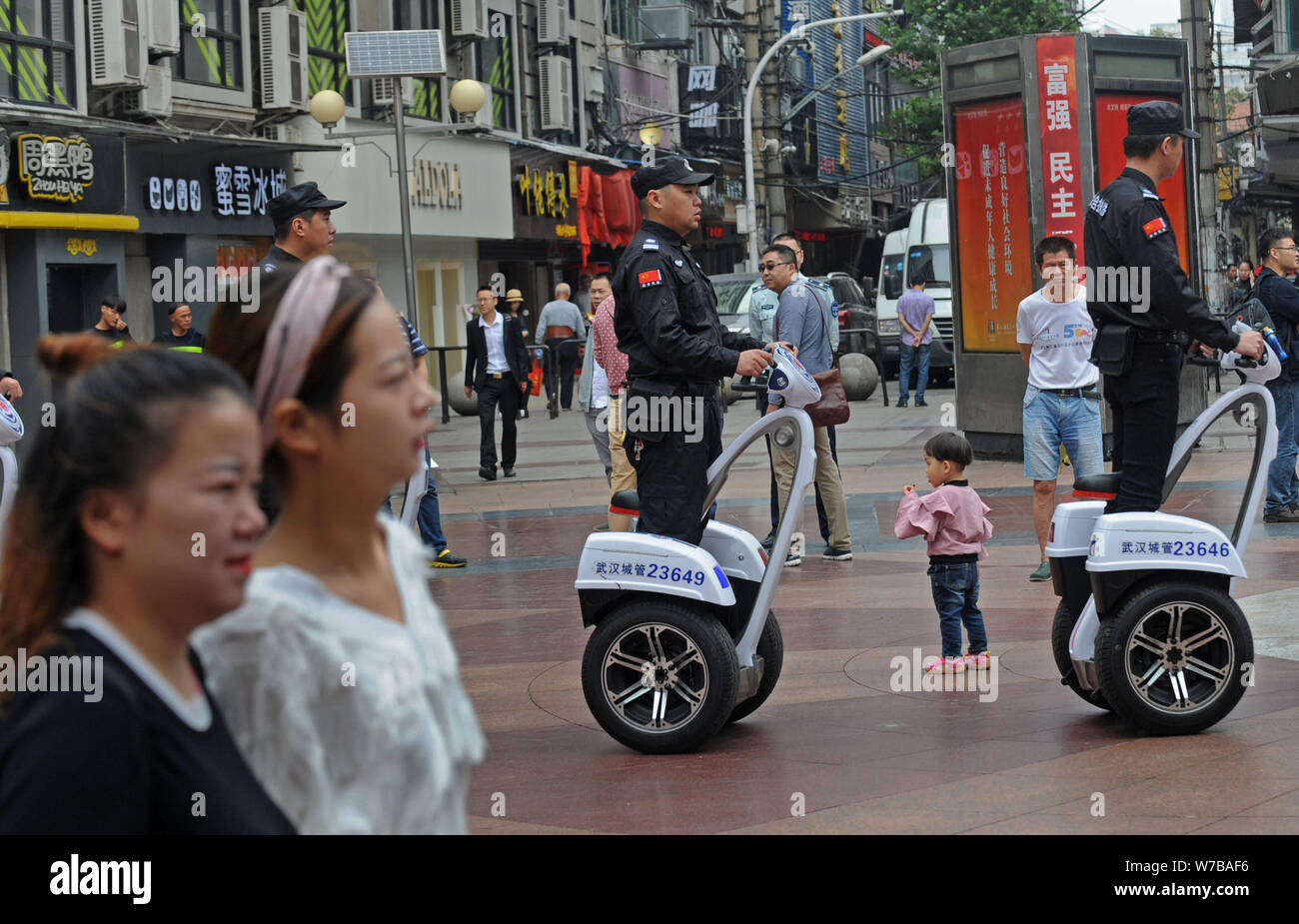 Local residents watch Chinese urban enforcement officers, also known as ...