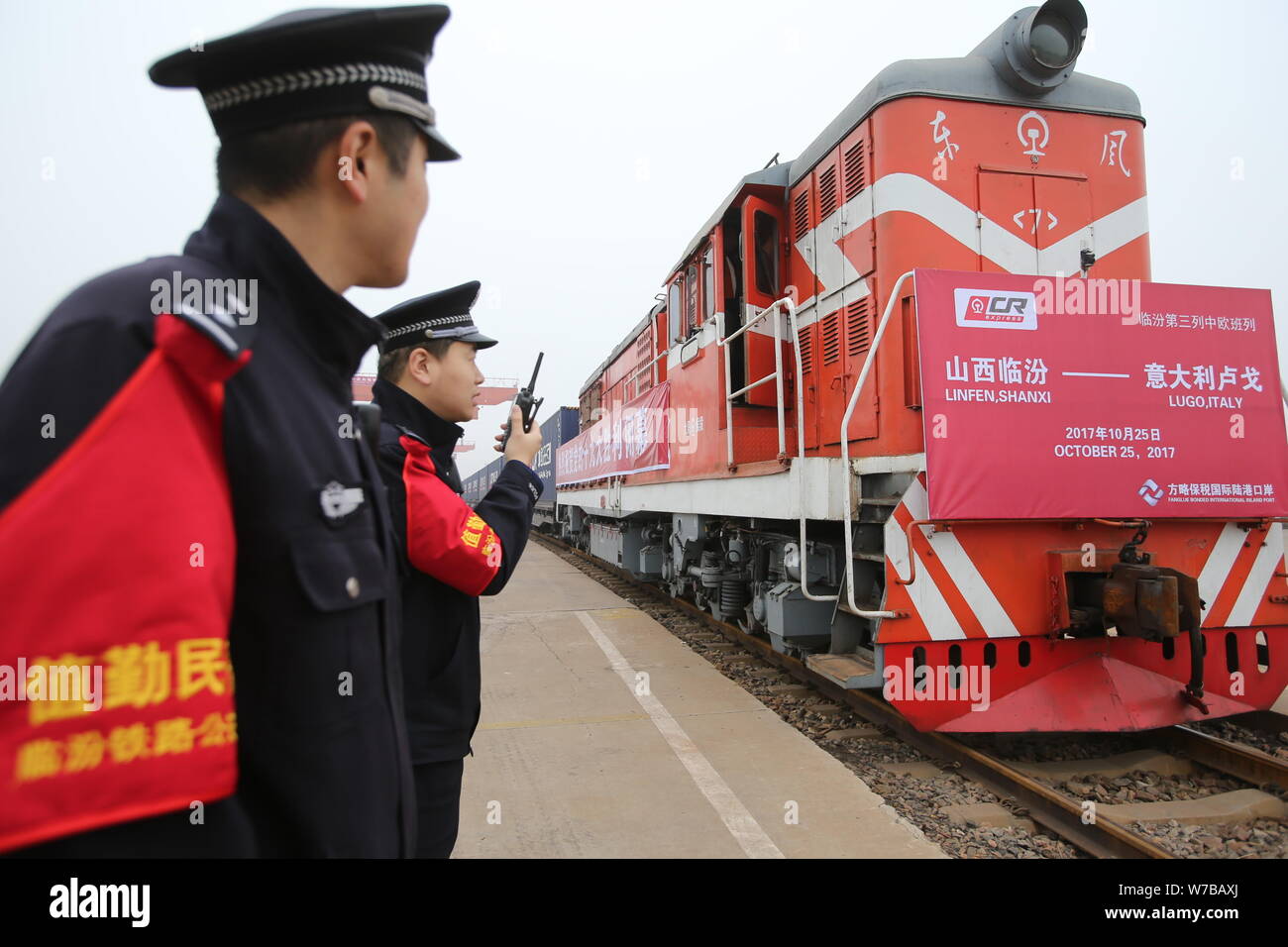 Chinese police officers look at a freight train of China Railway ...