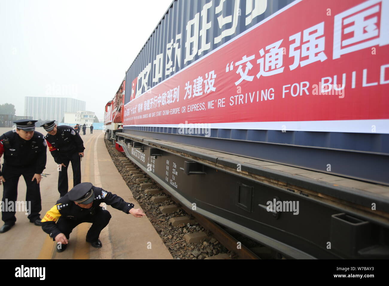 Chinese police officers check a freight train of China Railway Express ...