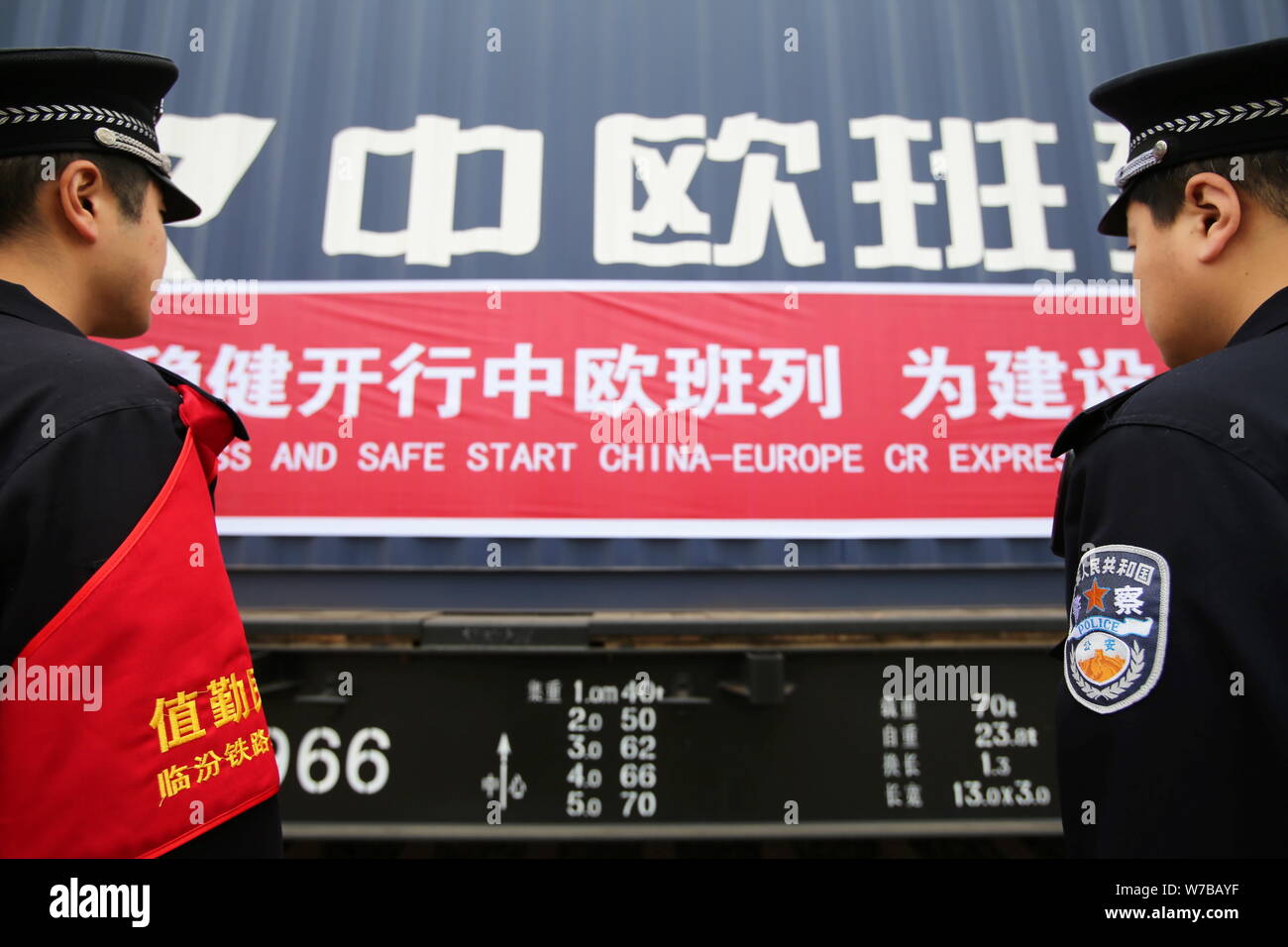 Chinese police officers look at a freight train of China Railway ...
