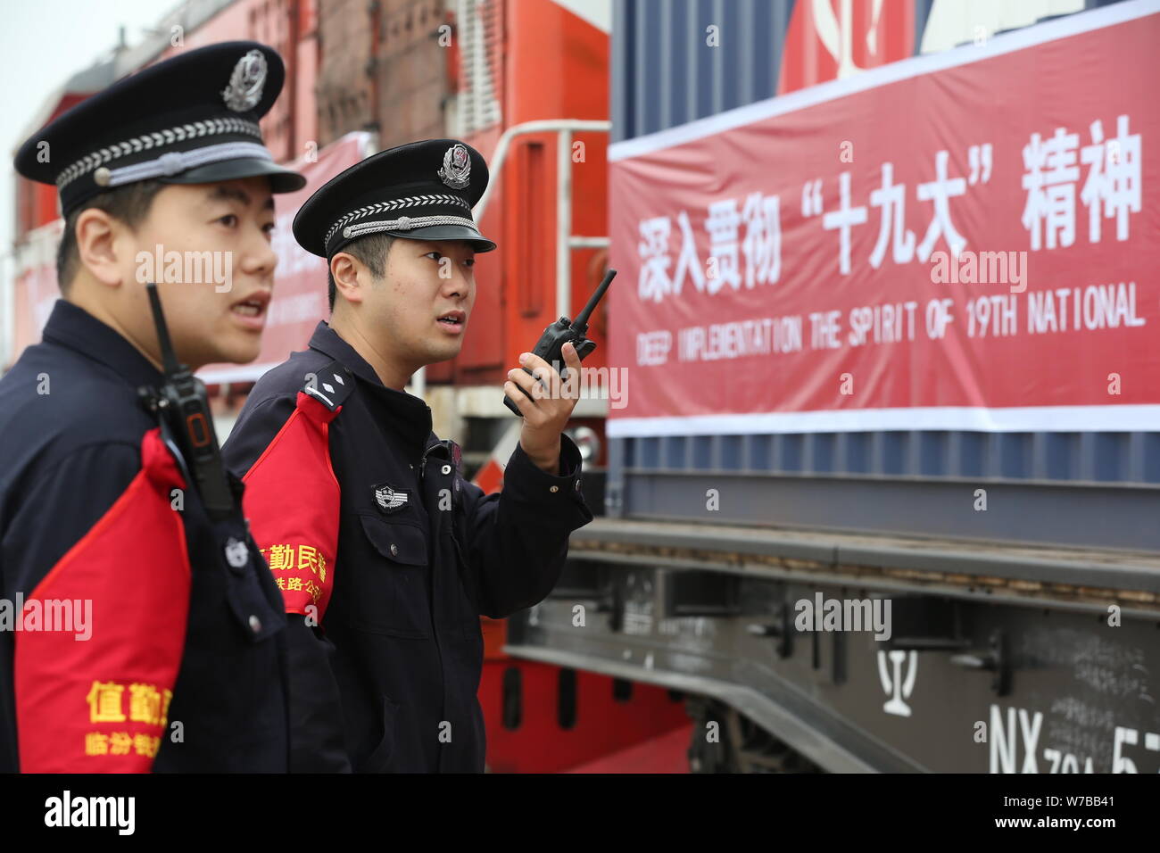 Chinese police officers look at a freight train of China Railway ...