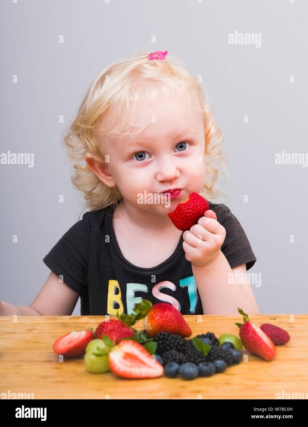 Happy little boy eating strawberries hi-res stock photography and ...