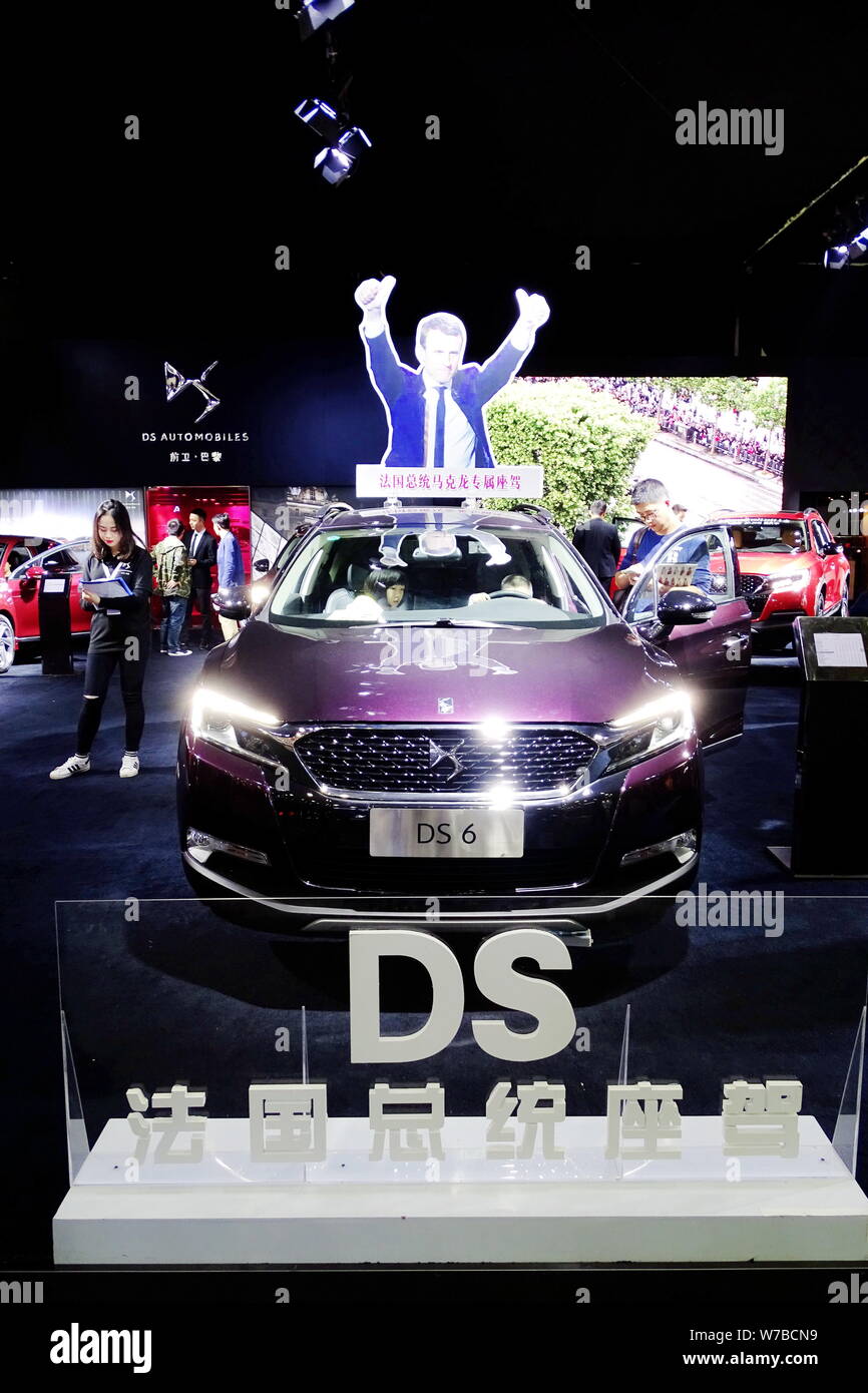 Visitors try out a Citroen DS 6 SUV with a signboard of French ...