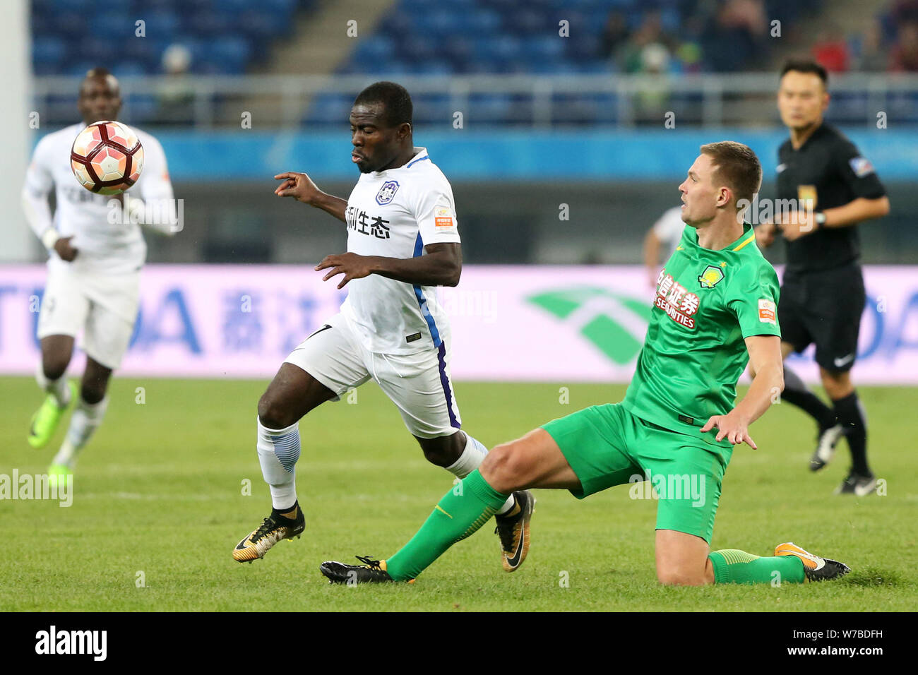 Ghanaian football player Frank Acheampong, left, of Tianjin TEDA kicks ...