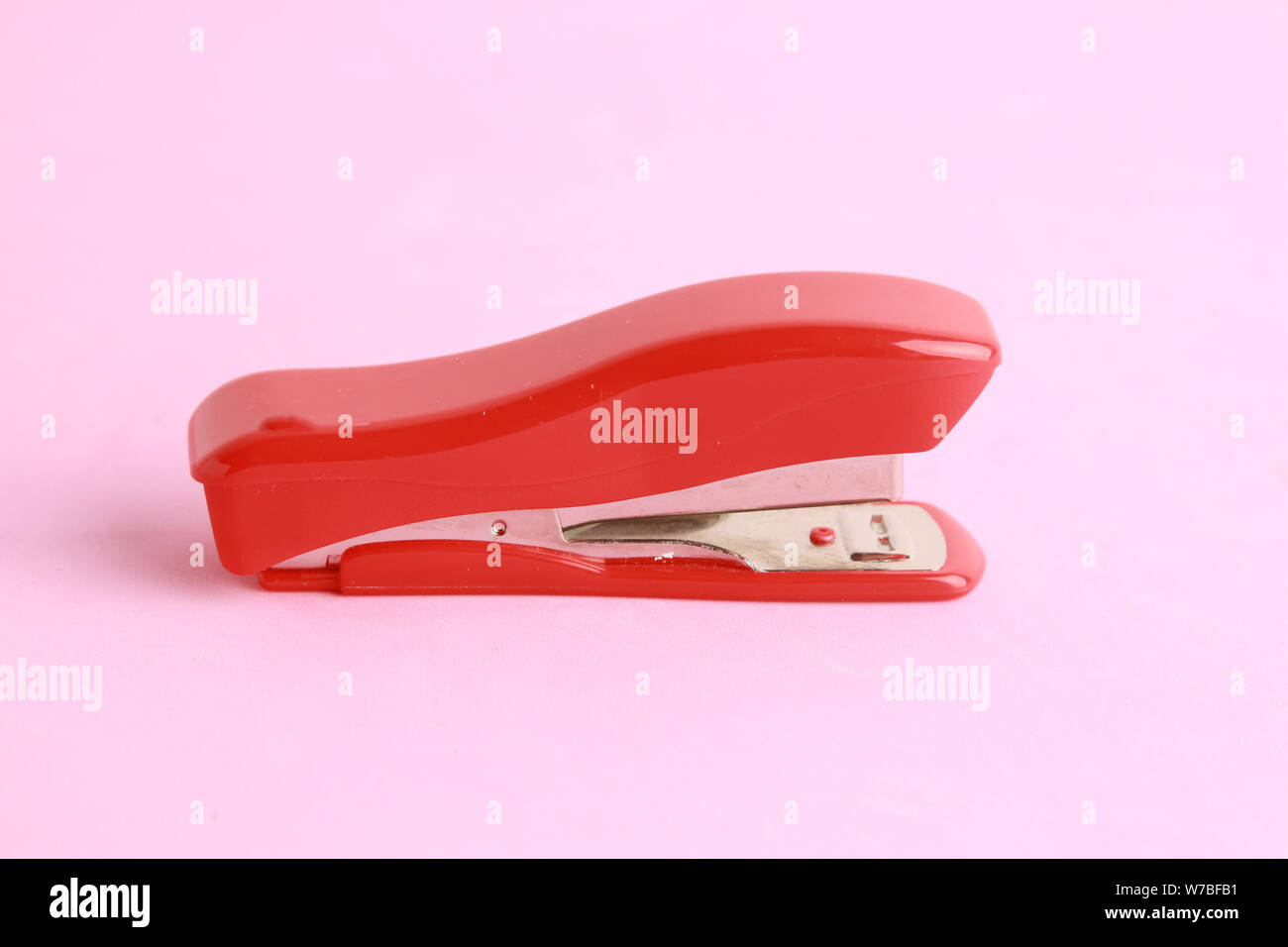 red stapler in color background Stock Photo - Alamy