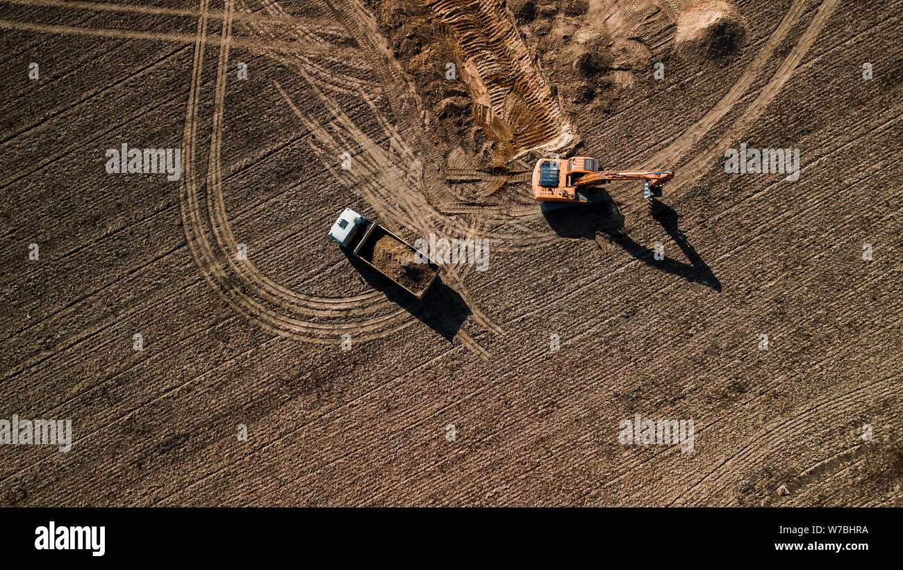 excavator loads truck aerial view from above with drone Stock Photo - Alamy