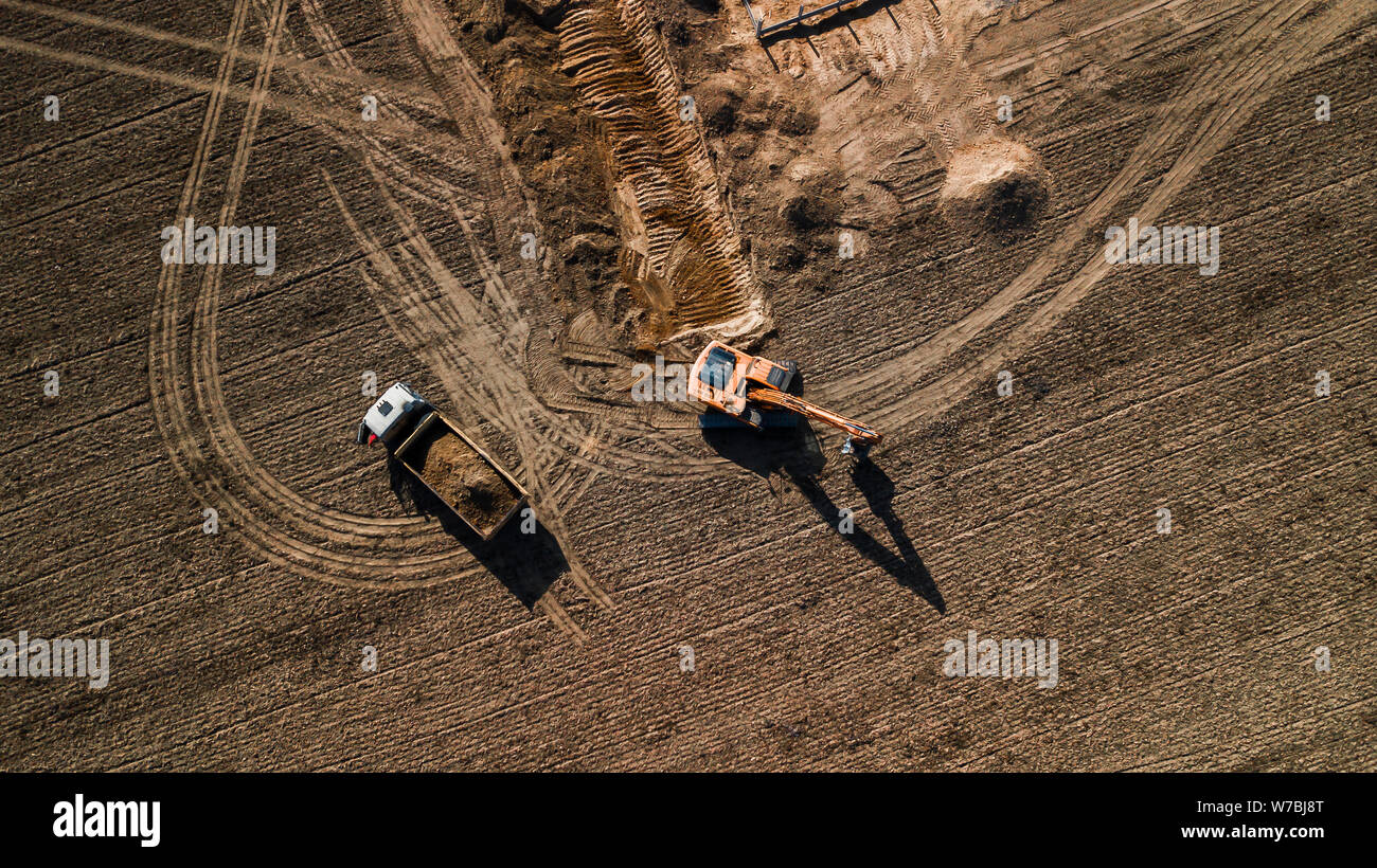 excavator loads truck aerial view from above with drone Stock Photo - Alamy