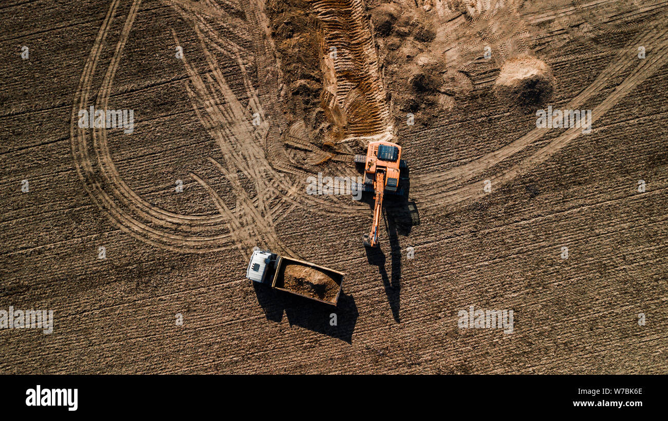 excavator loads truck aerial view from above with drone Stock Photo - Alamy