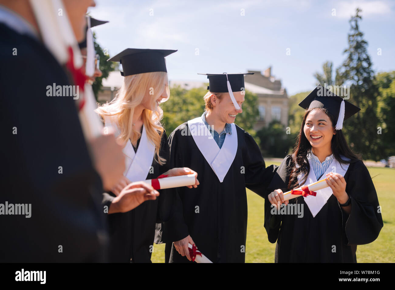 Cheerful young people graduating from the university Stock Photo - Alamy