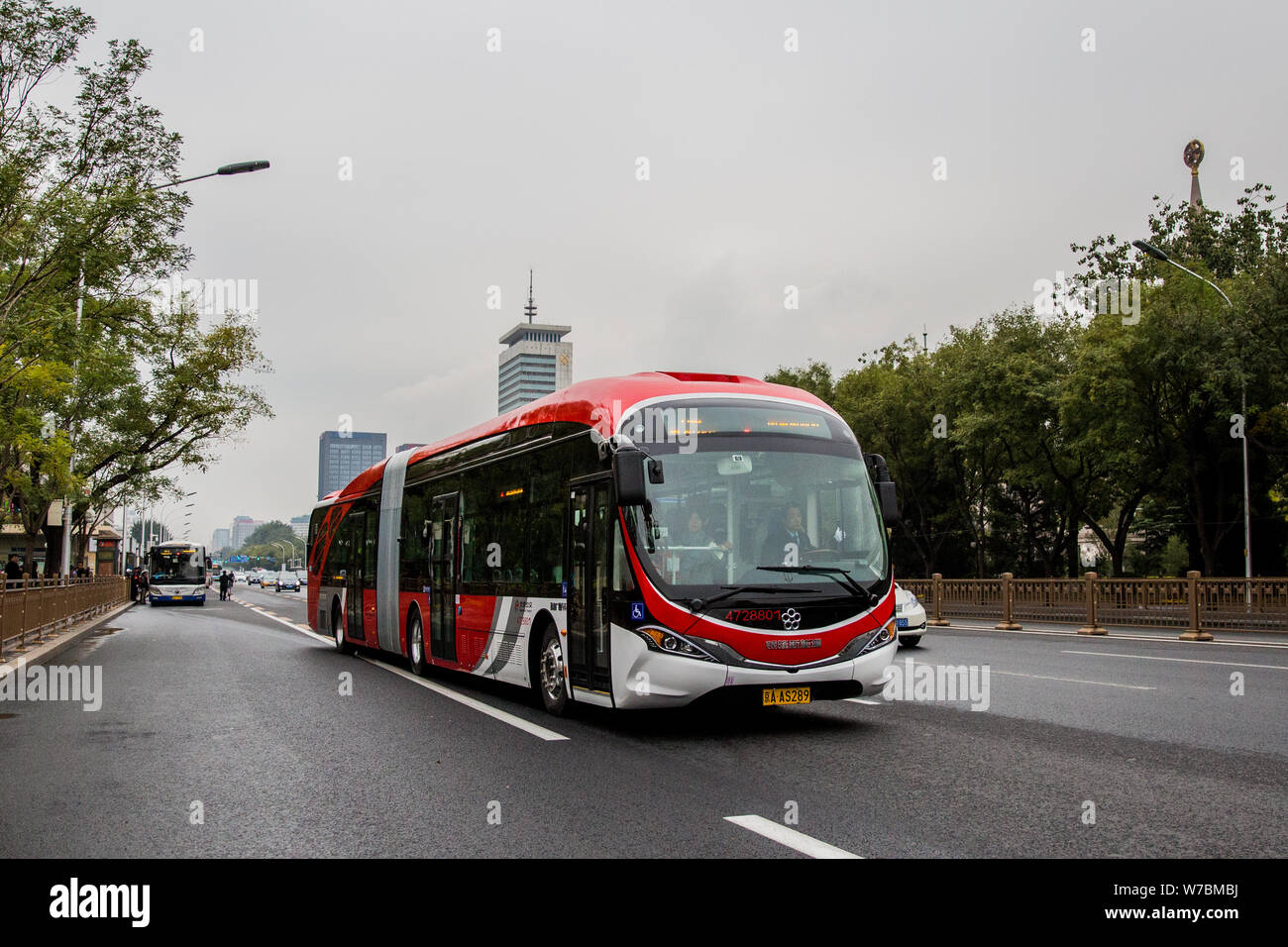 One of the first batch of 10 electric buses in red travels on a road in ...