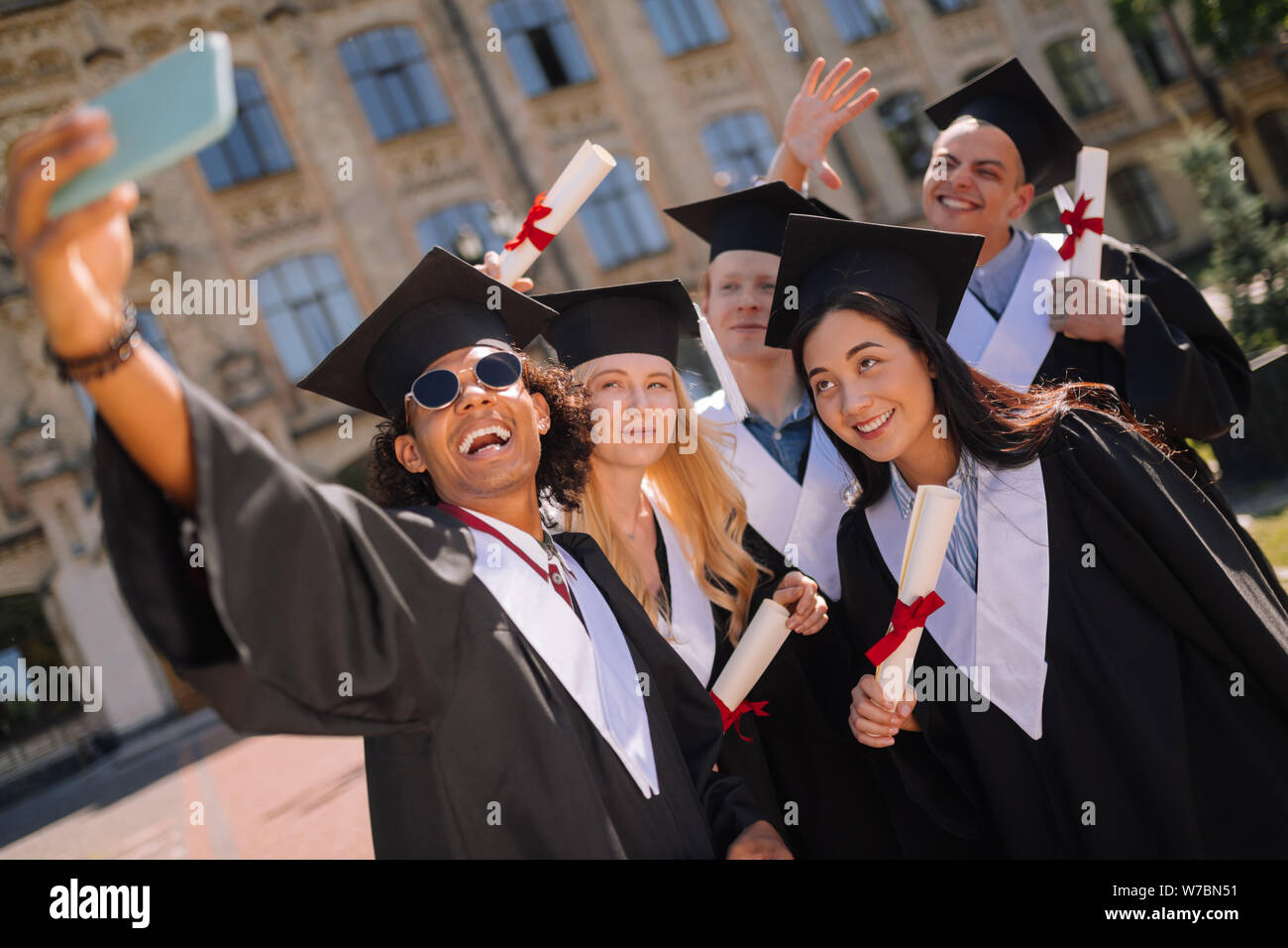Happy graduates taking a selfie together near university Stock Photo ...
