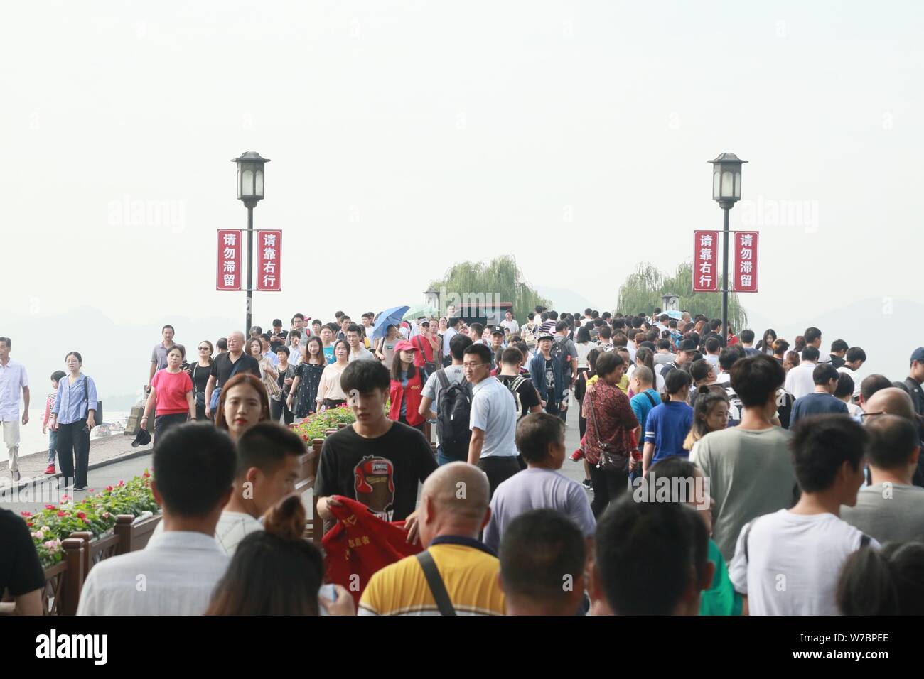 Tourists crowd the Broken Bridge on the West Lake during the National ...